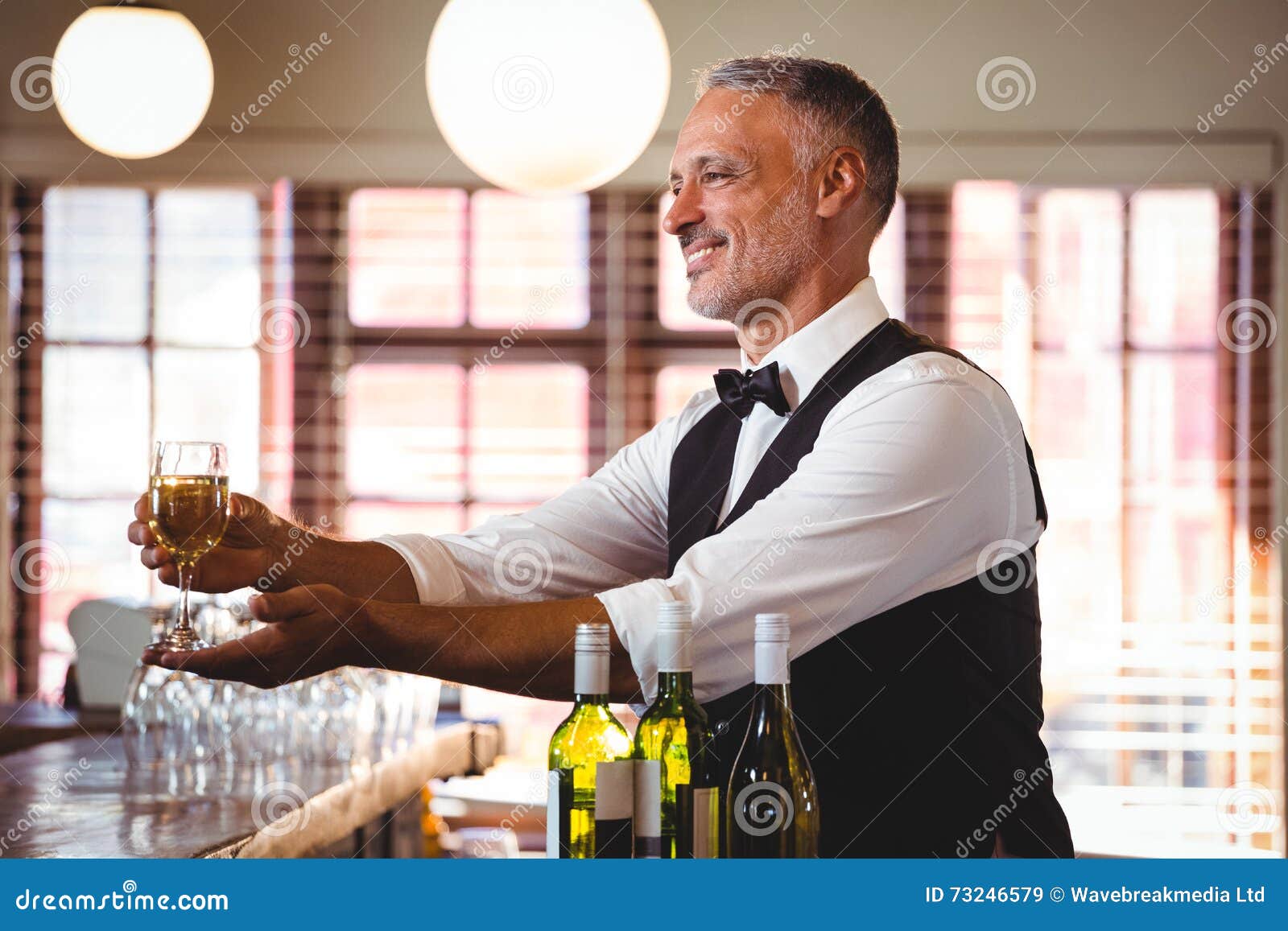 Smiling Bartender Offering a Glass of Wine at Bar Counter Stock Image ...