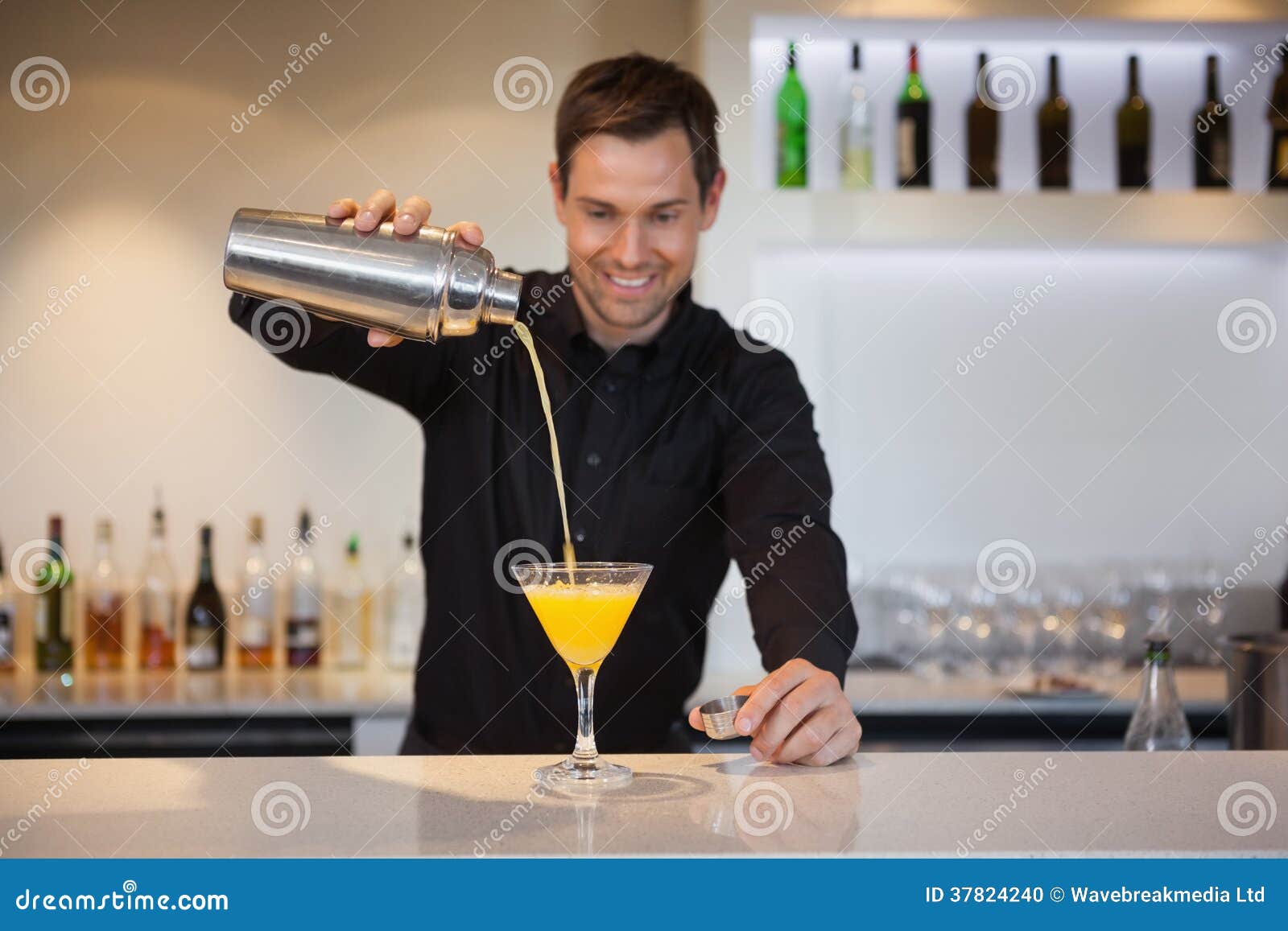 Smiling Bartender Pouring Yellow Cocktail into Glass Stock Photo ...
