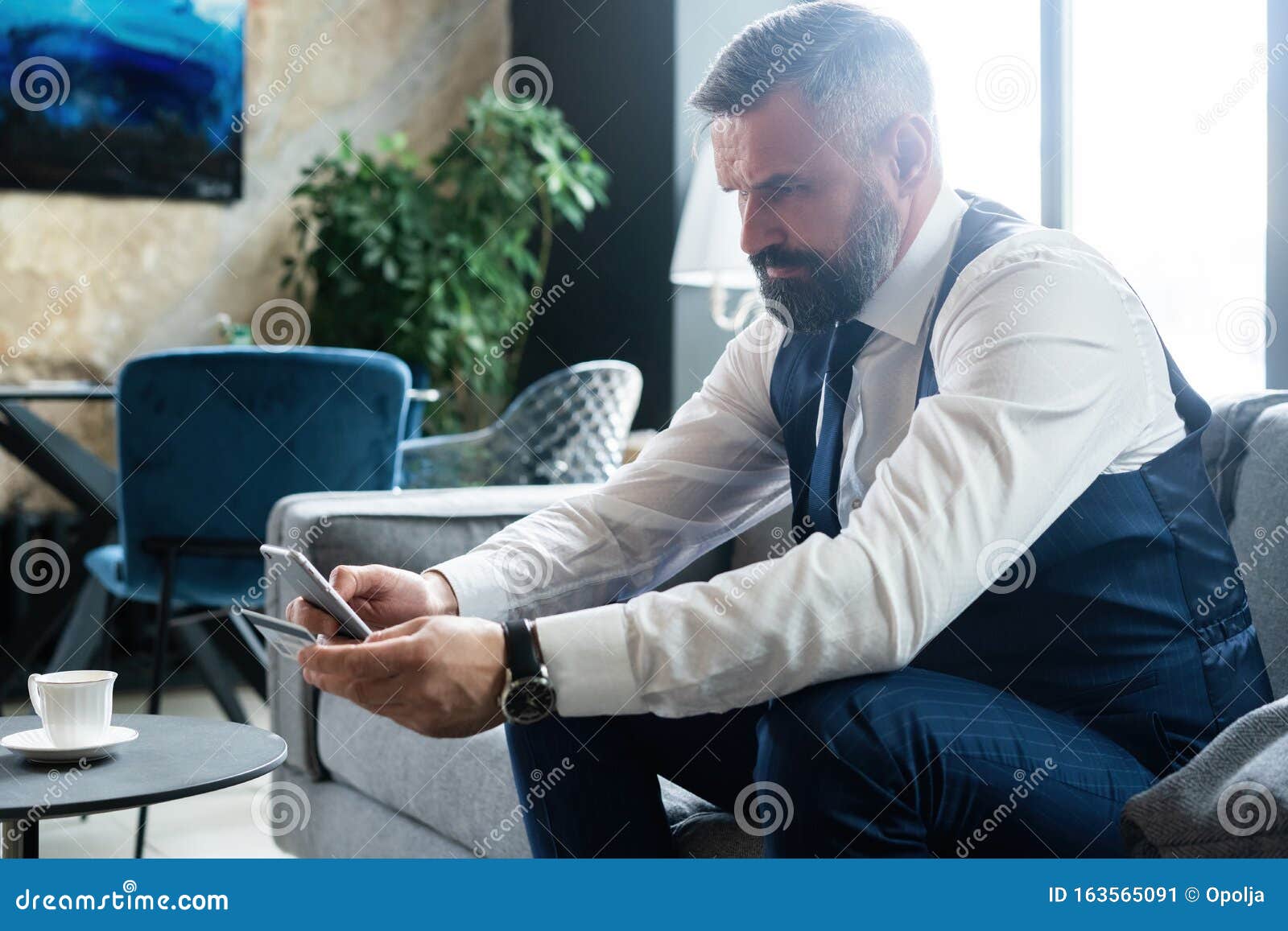 Smiling Bearded Man Making Text Message on Smartphone while Sitting ... Smiling Bearded Man Making Text Message on Smartphone while Sitting ...