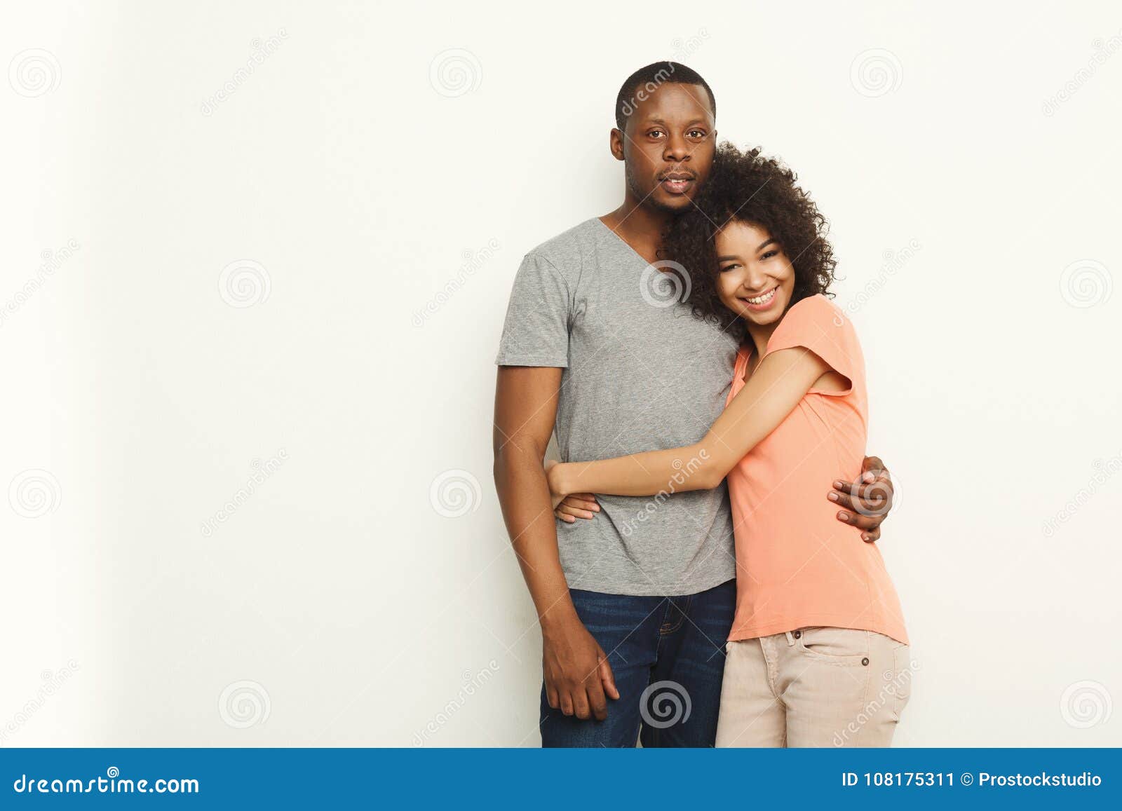 Smiling Black Couple In Casual Embracing At White Studio Background ... Smiling Black Couple In Casual Embracing At White Studio Background ...