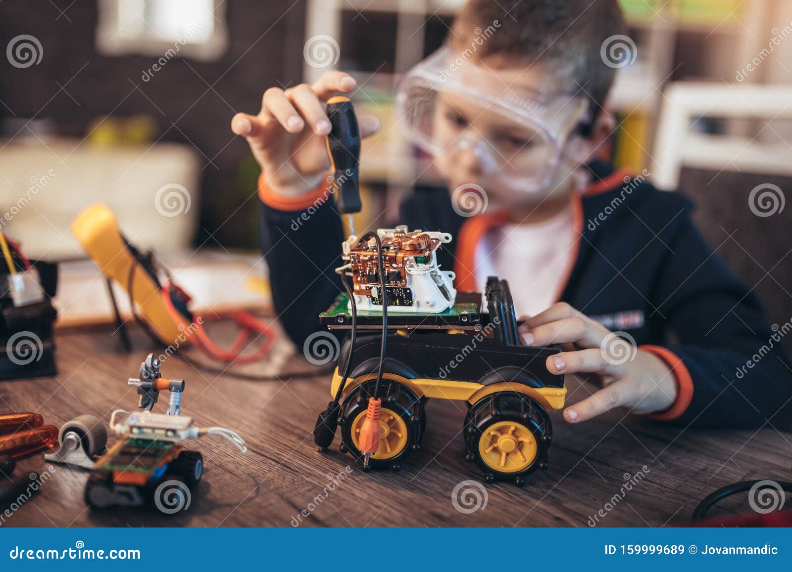 Smiling Boy Constructs Technical Toy. Technical Toy on Table Full of ...