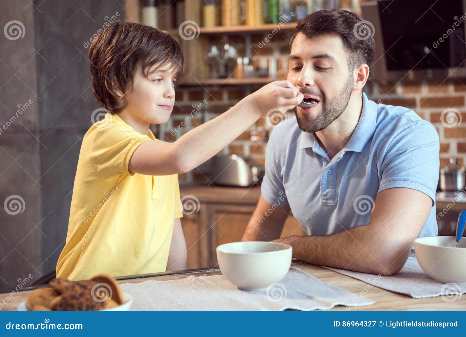 Smiling Boy Feeding Father with Breakfast Stock Image - Image of ...