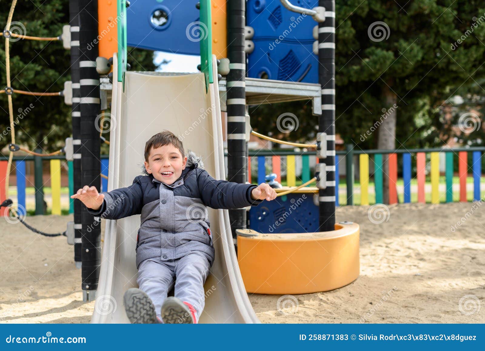 Smiling Boy Having Fun Going Down a Slide at a Playground Stock Image ...
