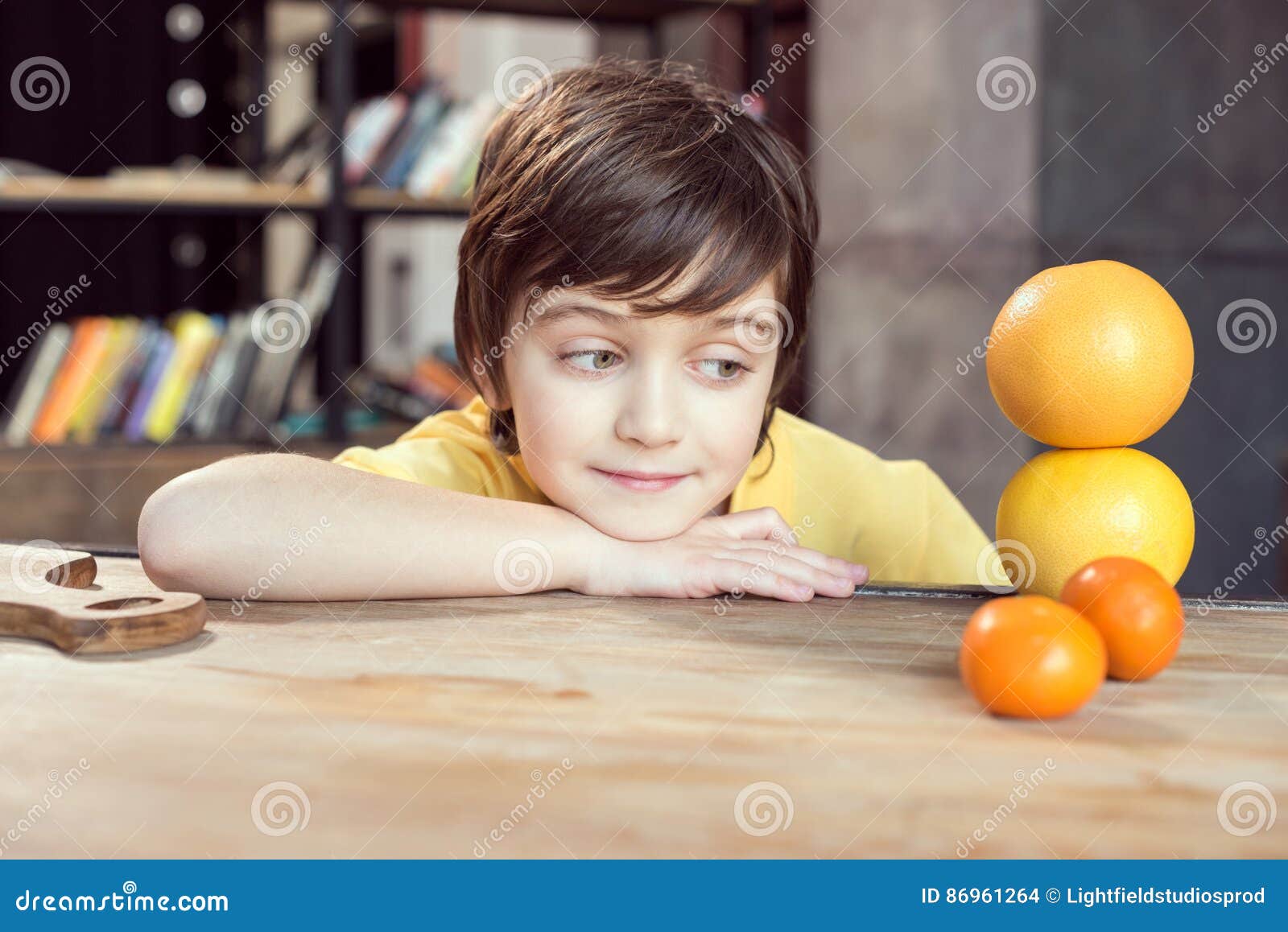 Smiling Boy Leaning at Table and Looking at Fresh Fruits Stock Photo ...