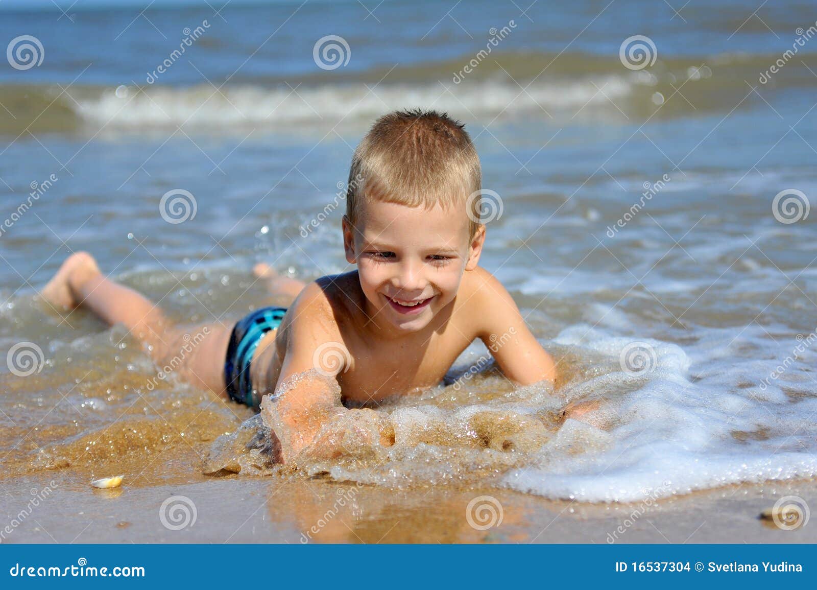 Smiling Boy Lying In Water At The Beach Stock Photography ...