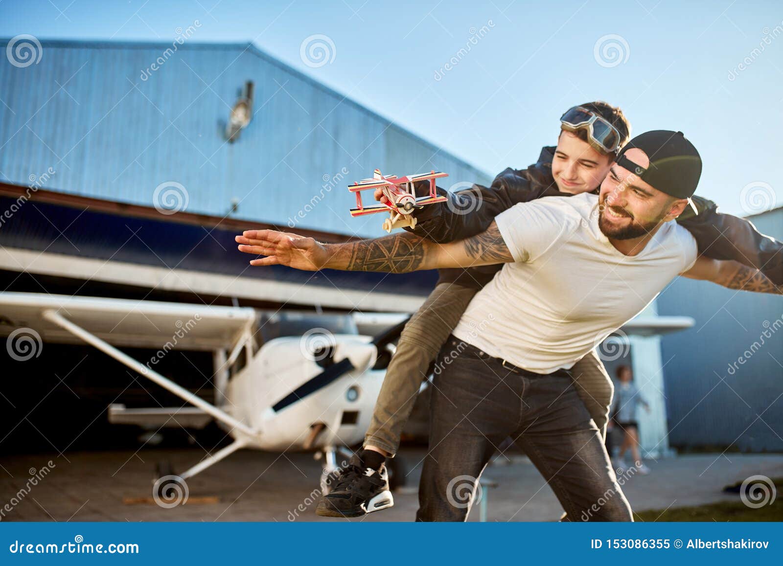 Smiling Boy with Model Plane, Riding on Father`s Back, Playing Outside ...