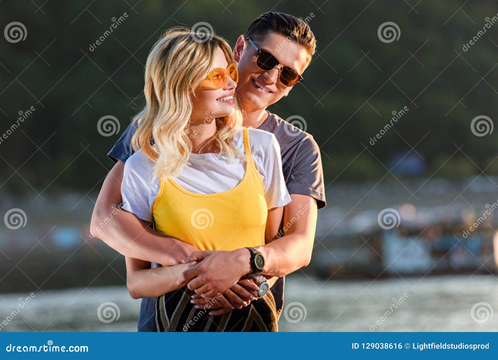 Smiling Boyfriend Cuddling Girlfriend on River Beach Stock Photo ...