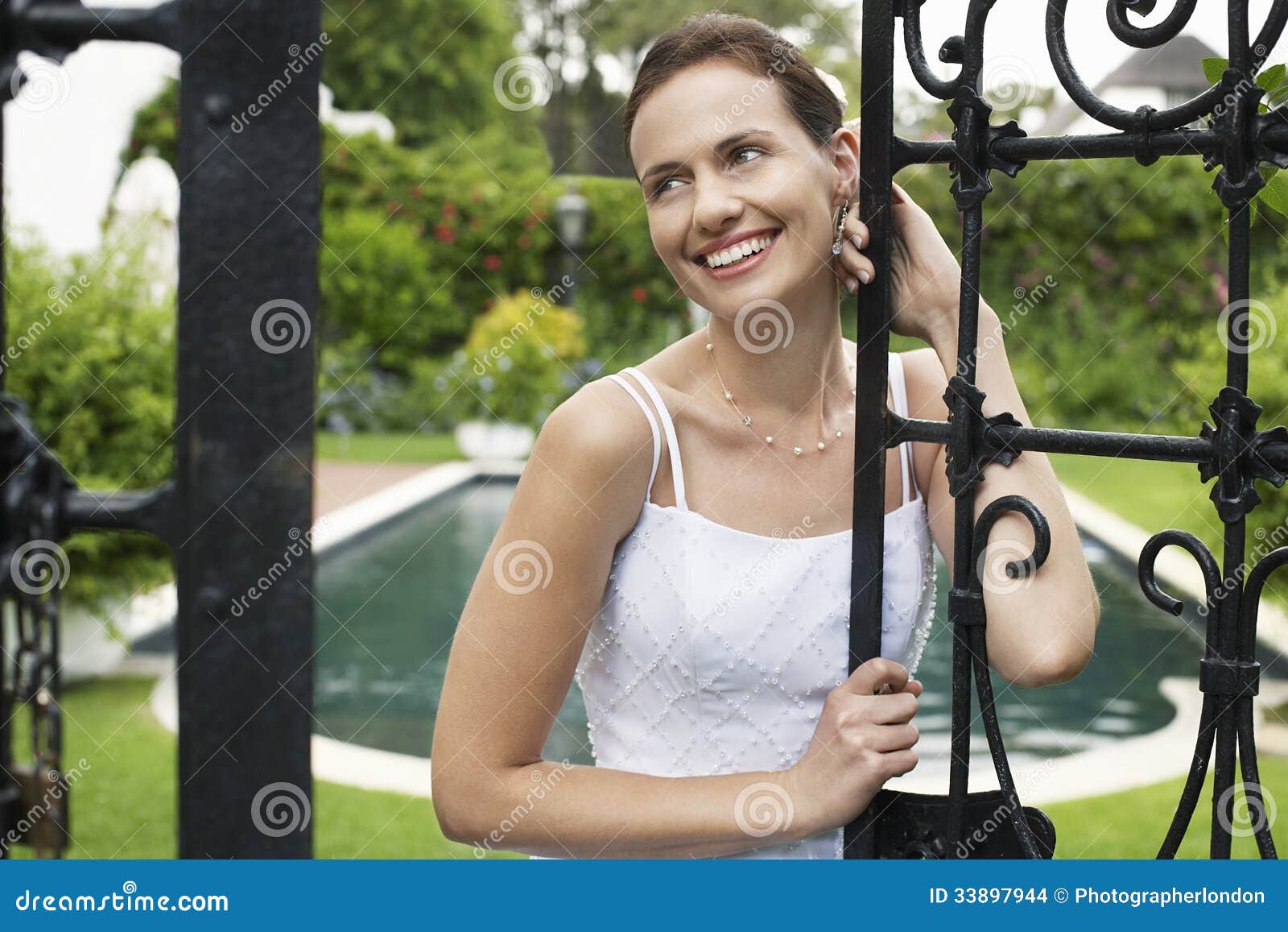 Smiling Bride Leaning on Garden Gate Stock Photo - Image of garden ...
