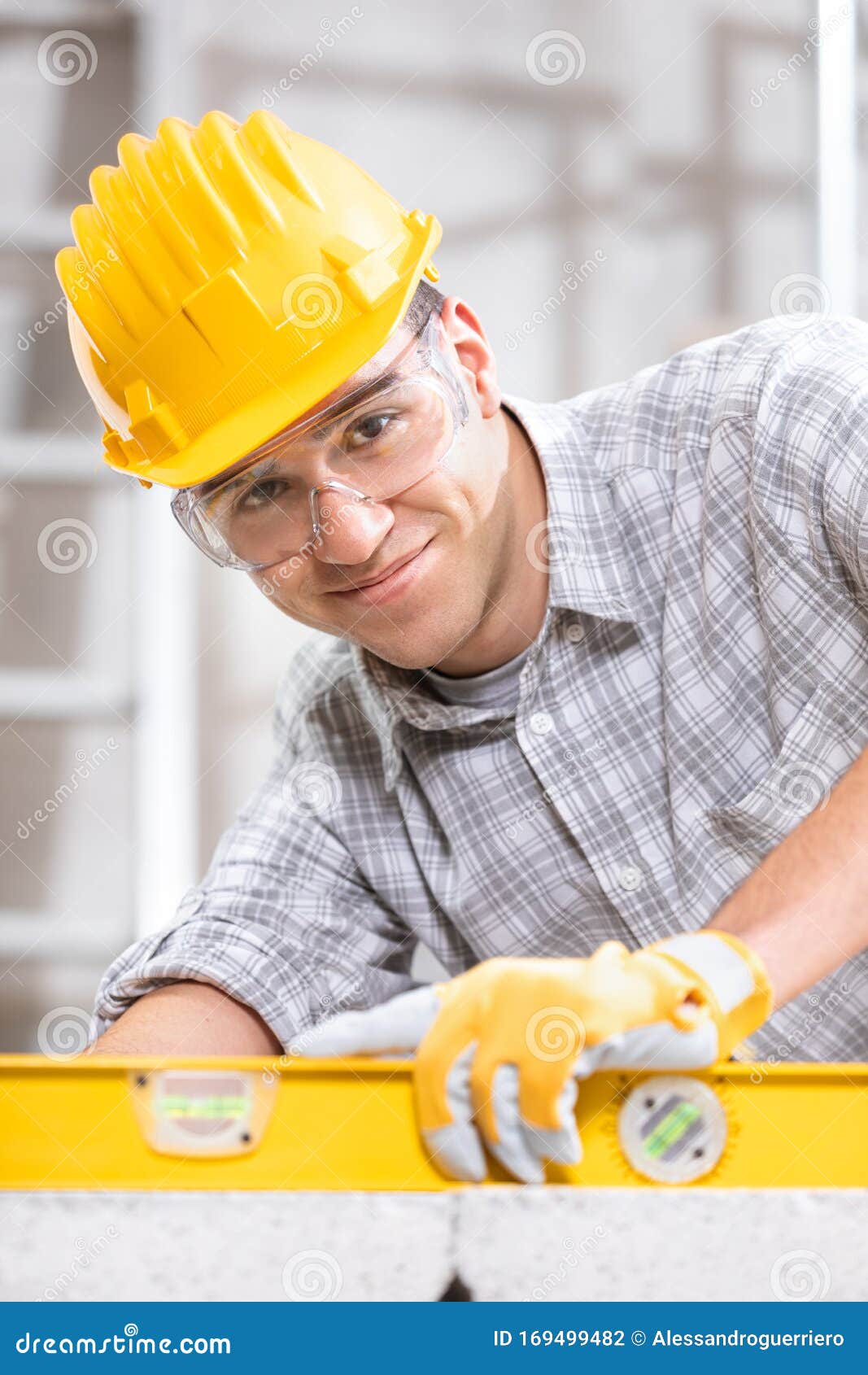 Smiling Builder in a Hardhat Using a Spirit Level Stock Photo - Image ...