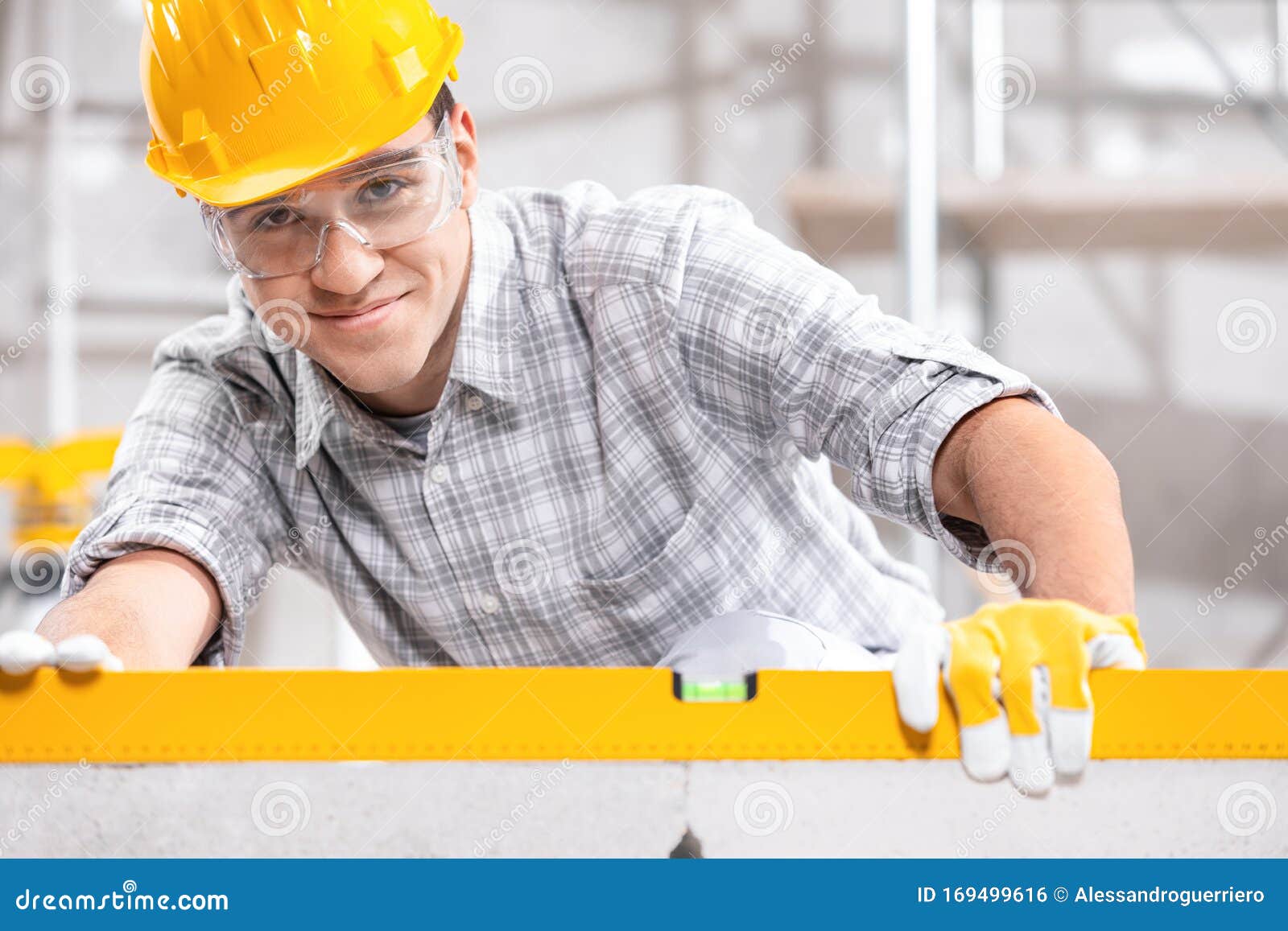 Smiling Builder in a Hardhat Using a Spirit Level Stock Photo - Image ...