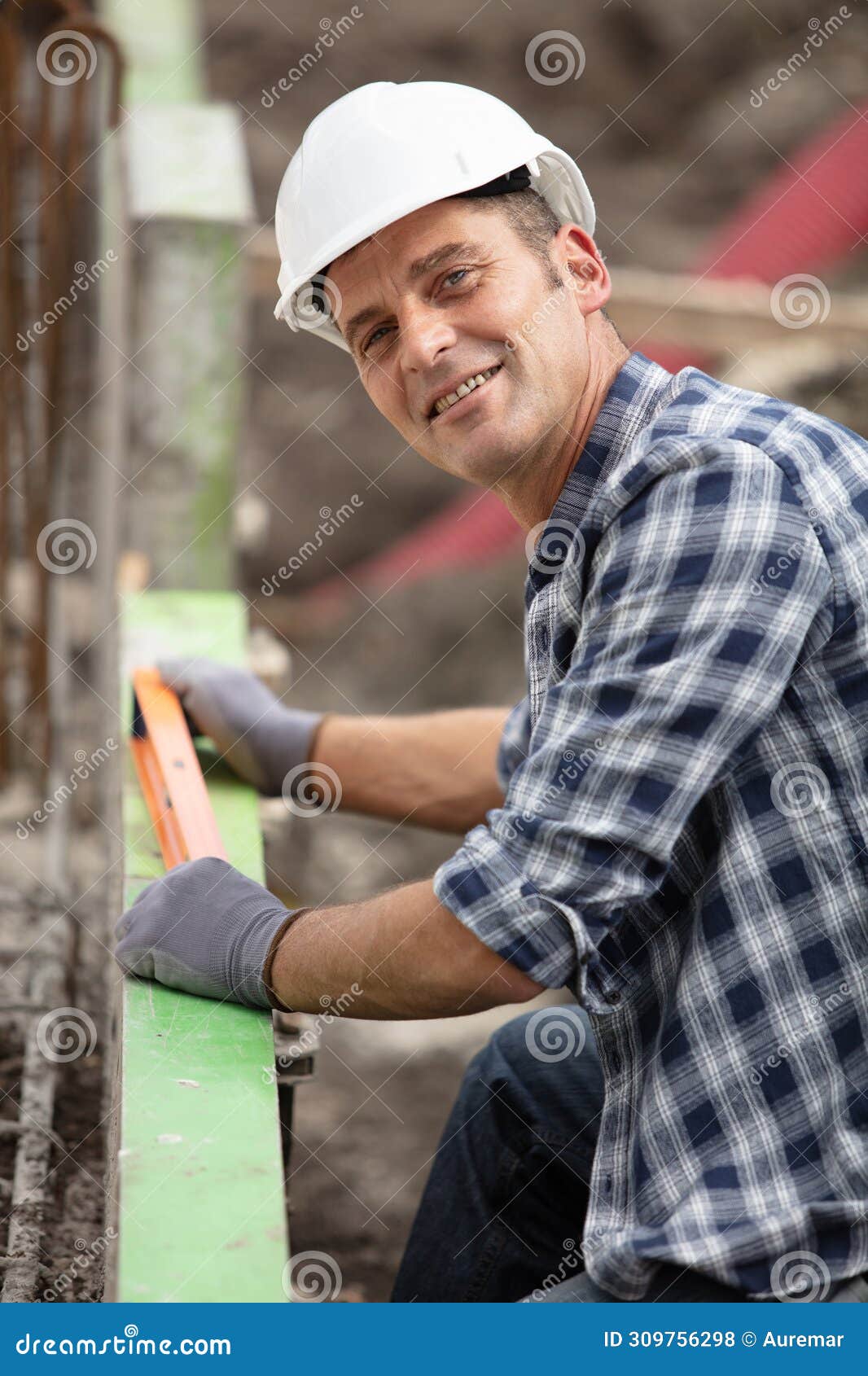 Smiling Builder Using Spirit Level on Construction Site Stock Photo ...