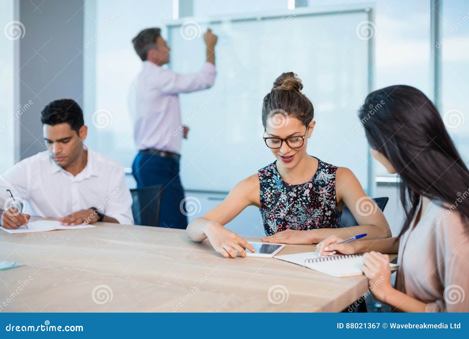 Smiling Business Colleagues Writing on Notepad and Using Digital Tablet ...