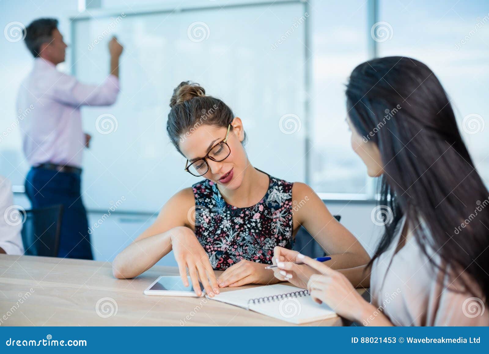 Smiling Business Colleagues Writing on Notepad and Using Digital Tablet ...