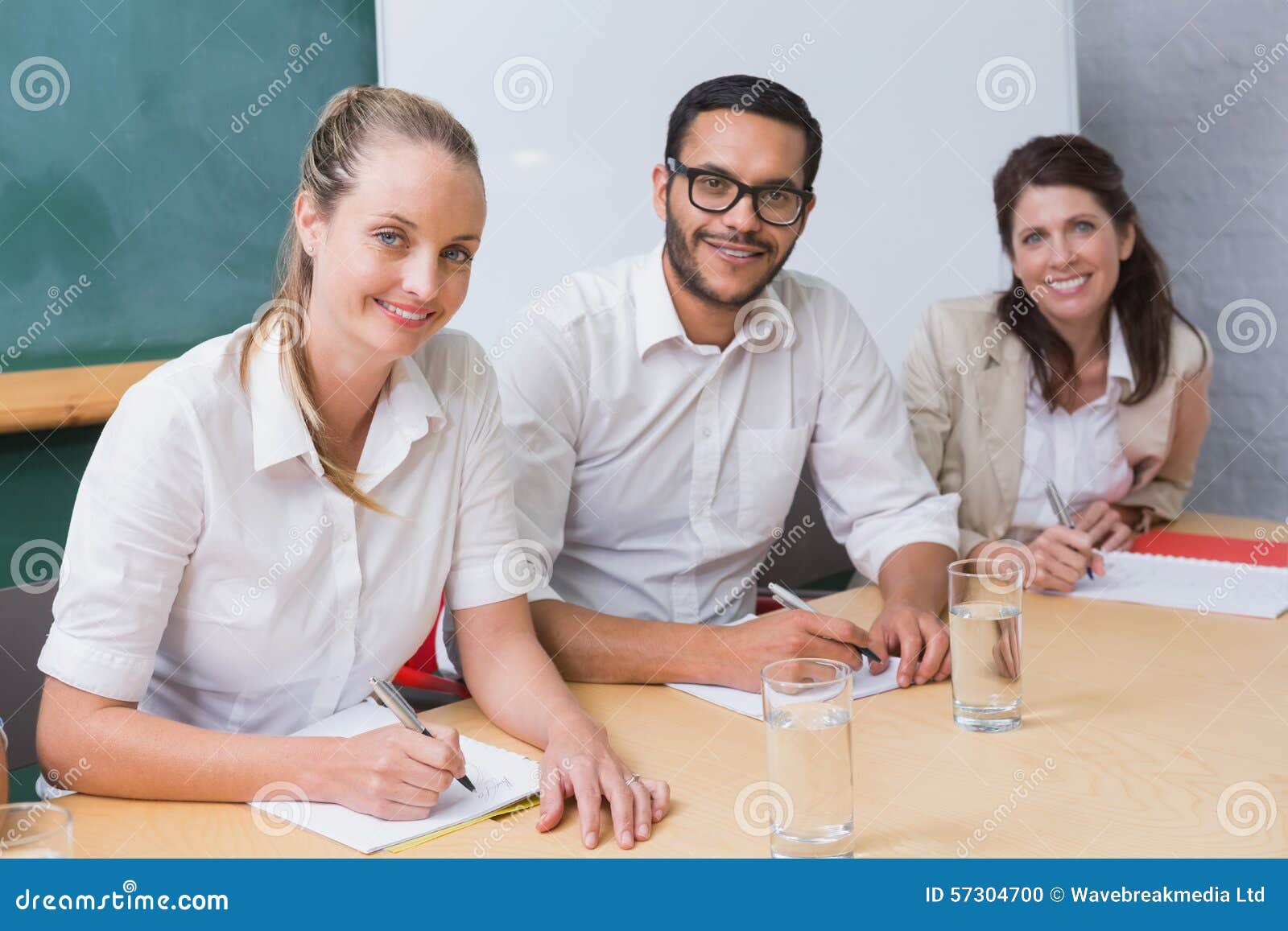 Smiling Business People Taking Notes during Meeting Stock Photo - Image ...