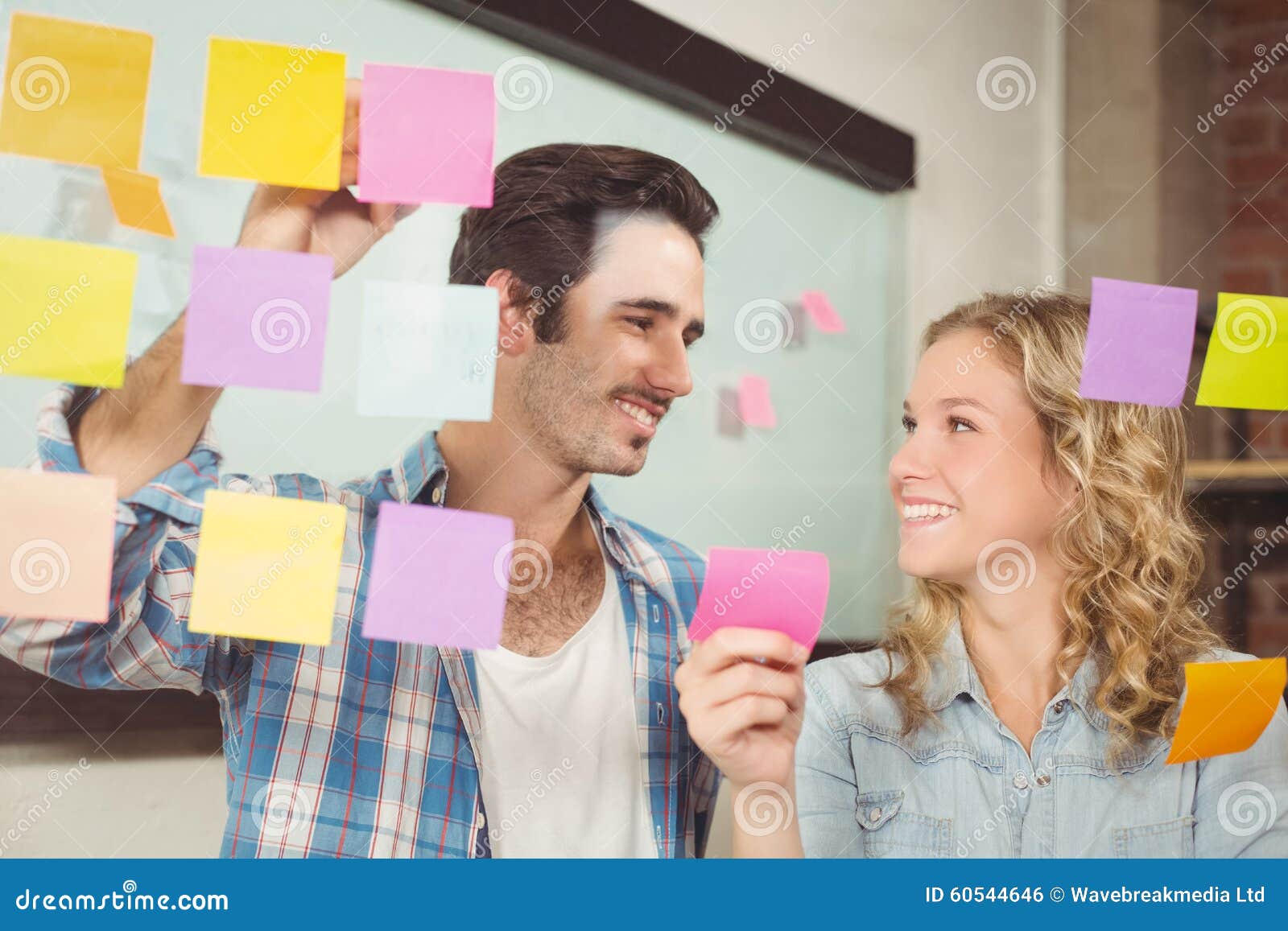 Smiling Business People Touching Sticky Notes on Glass in Office Stock ...