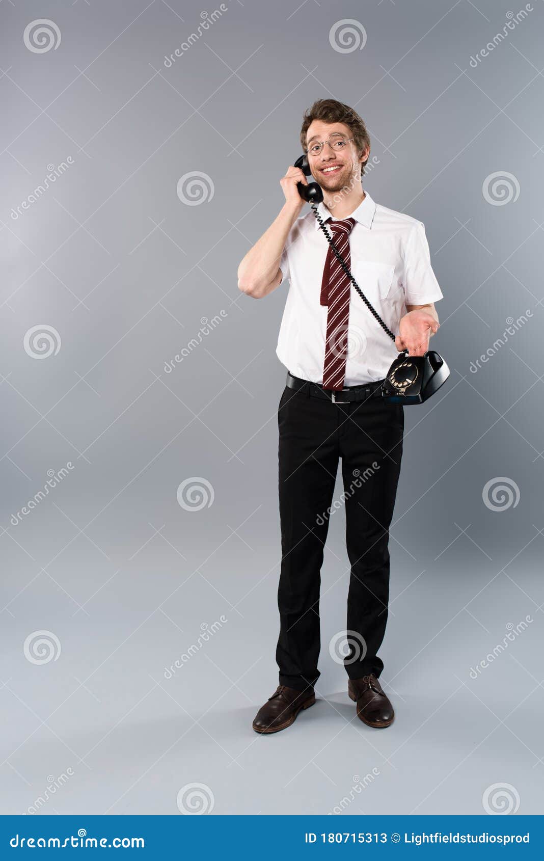 Smiling Businessman In Glasses Talking On Vintage Phone On Grey Stock