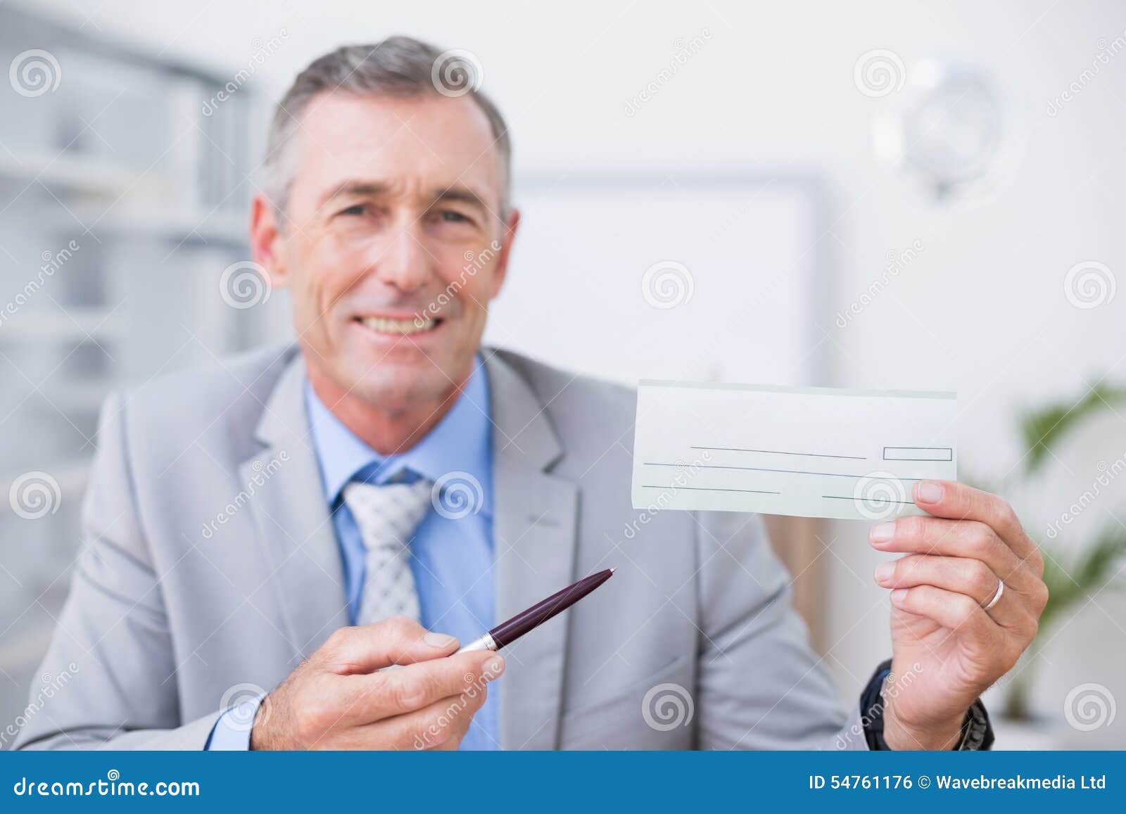 Smiling Businessman Holding Cheque Stock Photo - Image of sitting ...