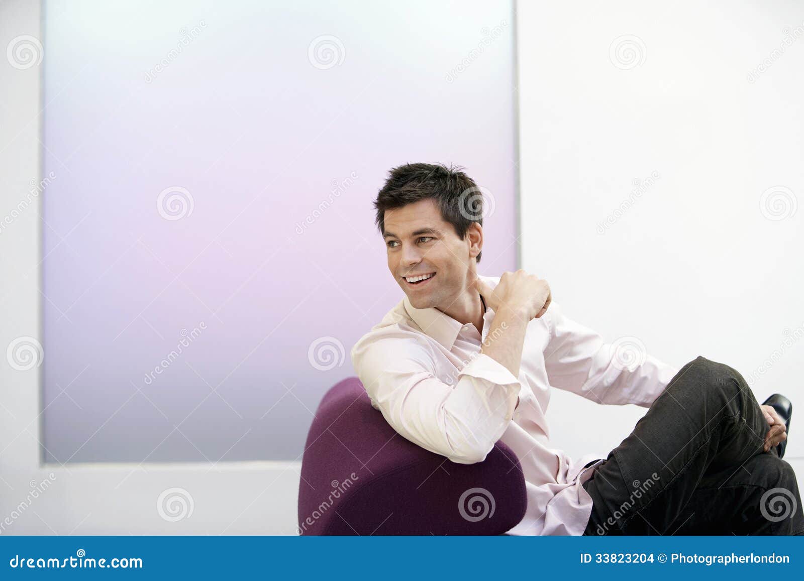 Smiling Businessman Looking Over Shoulder on Couch Stock Photo - Image ... Smiling Businessman Looking Over Shoulder on Couch Stock Photo - Image ...