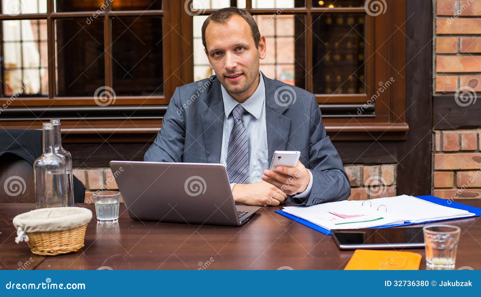 Smiling Businessman Making a Call with His Smartphone in a Restaurant ...
