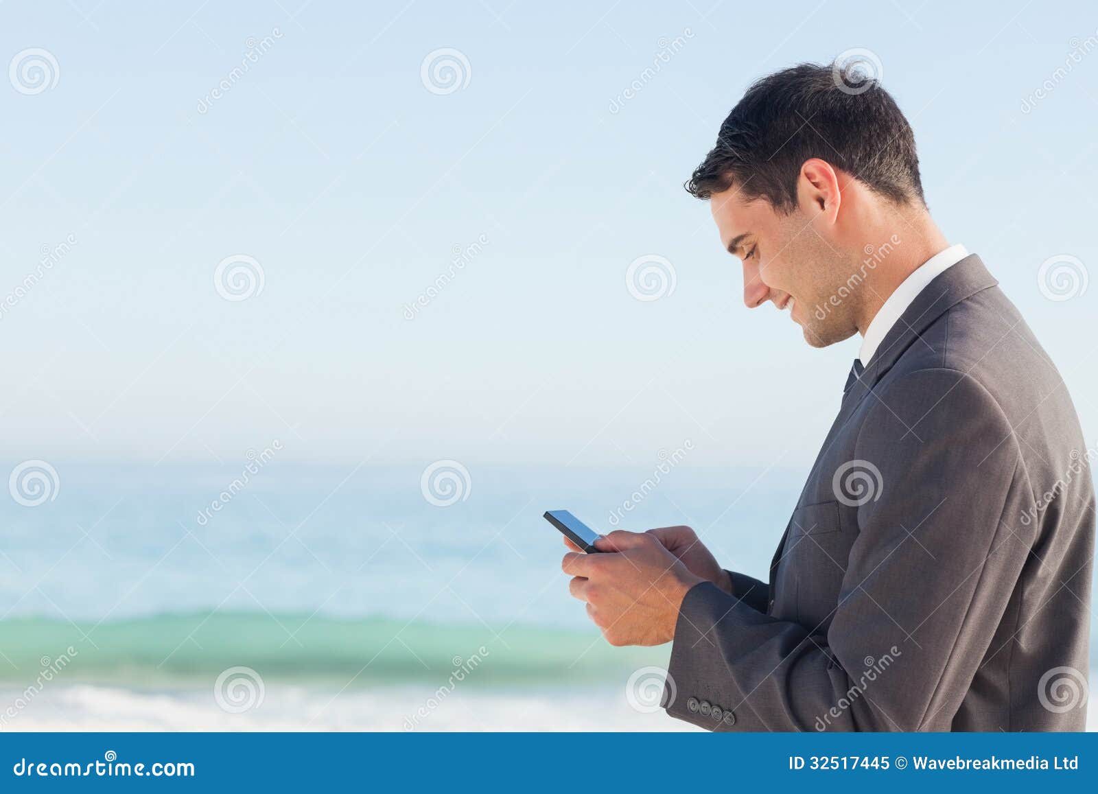 Smiling Businessman Sending a Text Message Stock Image - Image of ...