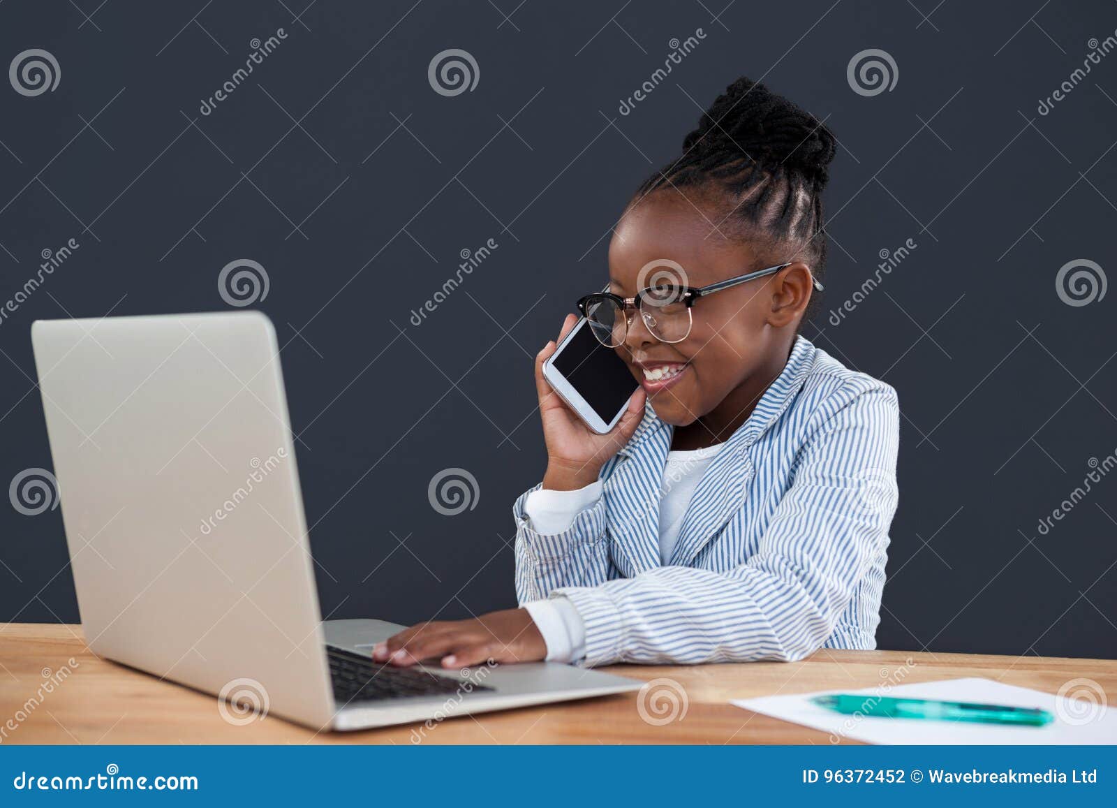 Smiling Businessman Using Mobile Phone while Working on Laptop Stock ...