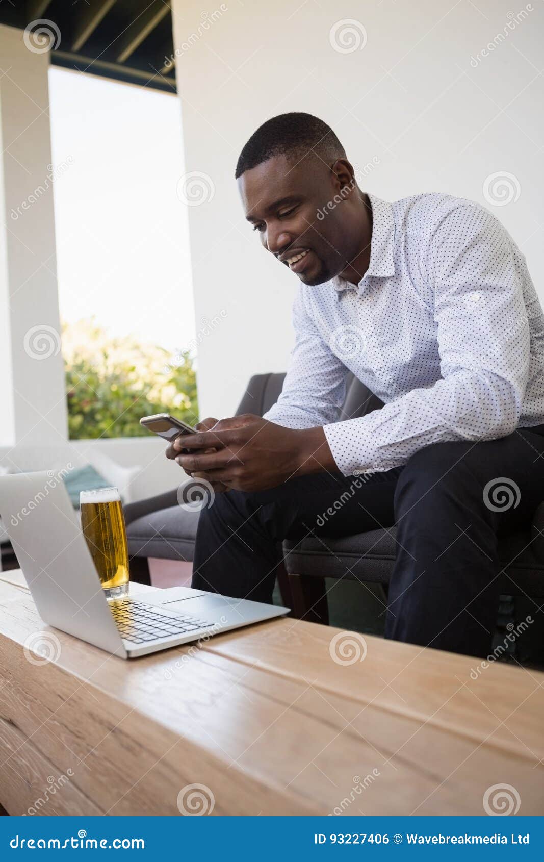 Smiling Businessman Using Phone while Sitting on Couch Stock Photo ...