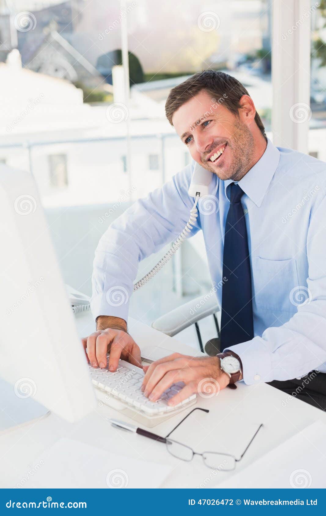 Smiling Businessman Working and Phoning at His Desk Stock Photo - Image ...