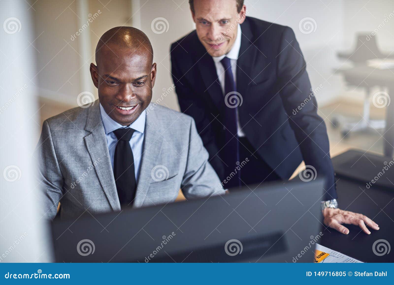 Smiling Businessmen Working on a Computer Together in an Office Stock ...