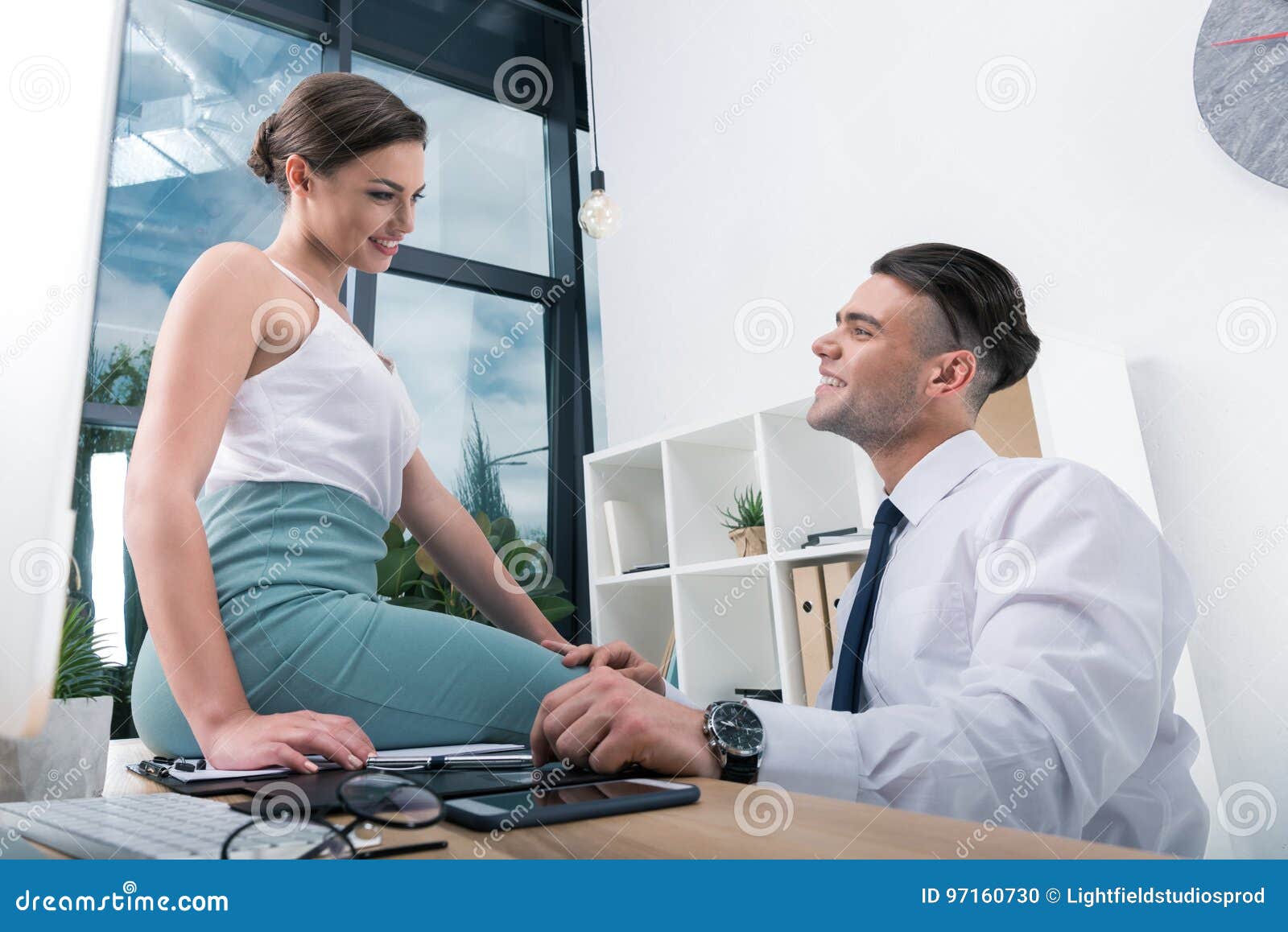 Smiling Businesspeople Talking while Sitting at Workplace in Office ...