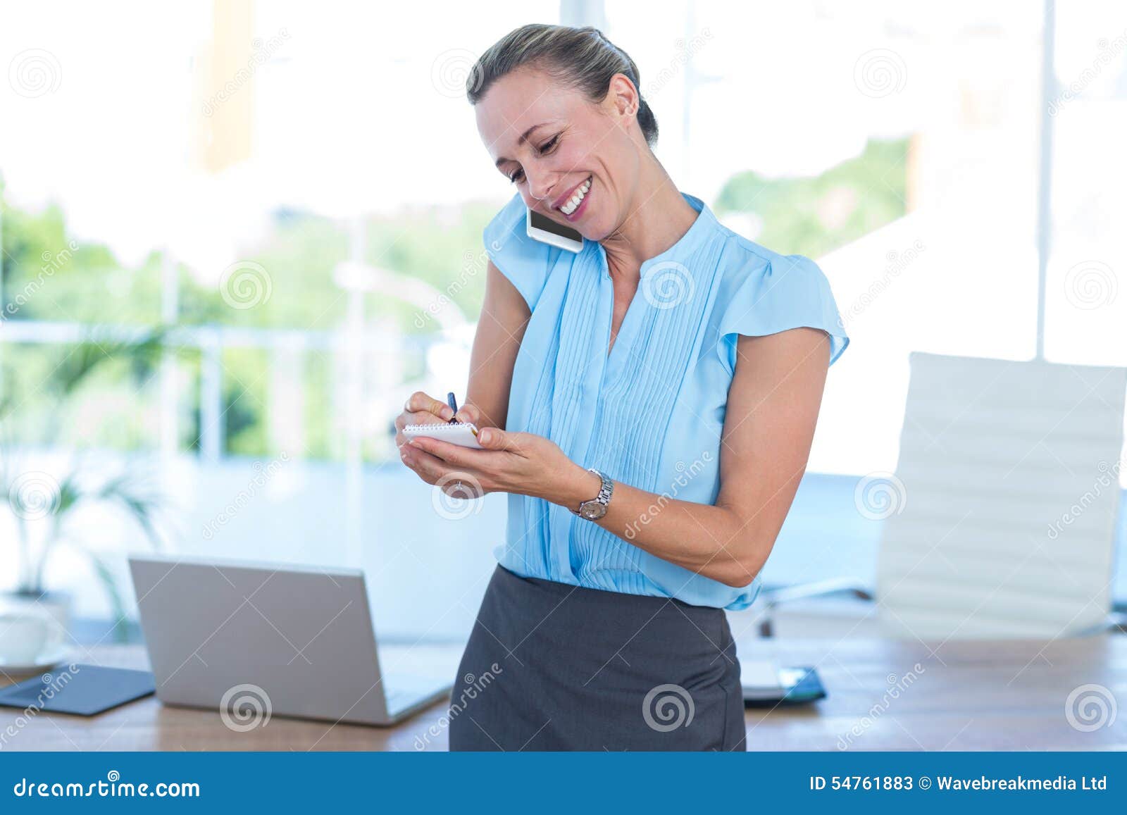 Smiling Businesswoman Having a Phone Call and Taking Notes Stock Image ...