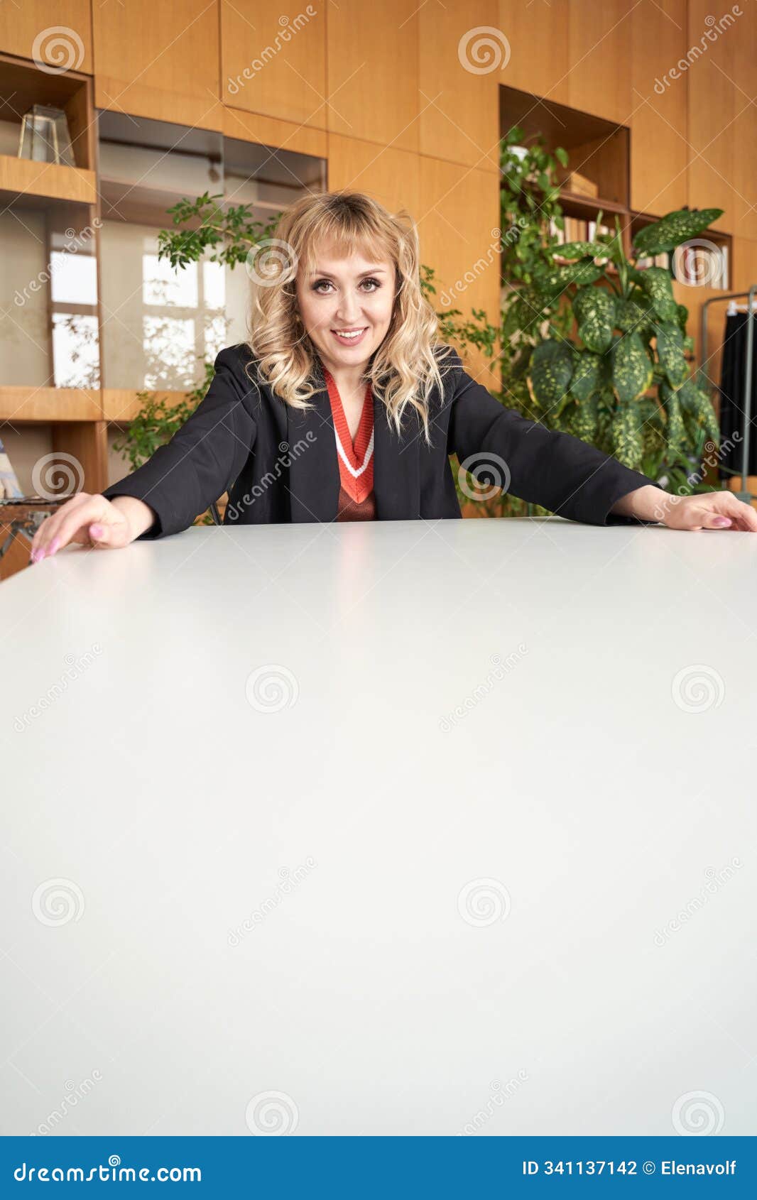 Smiling Businesswoman Leaning Forward at Conference Table in Modern ...
