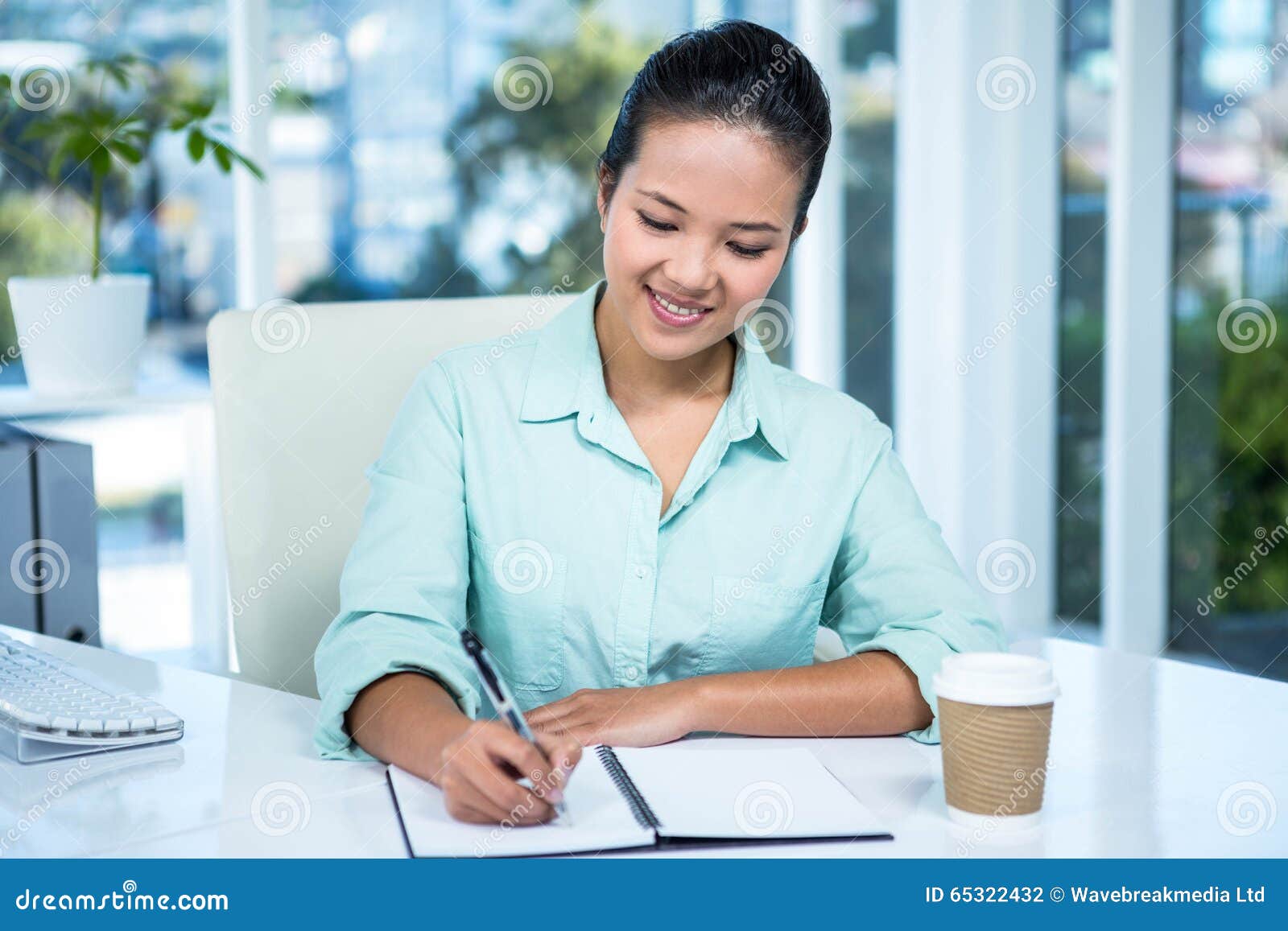Smiling Businesswoman Writing Notes with a Coffee Stock Photo - Image ...