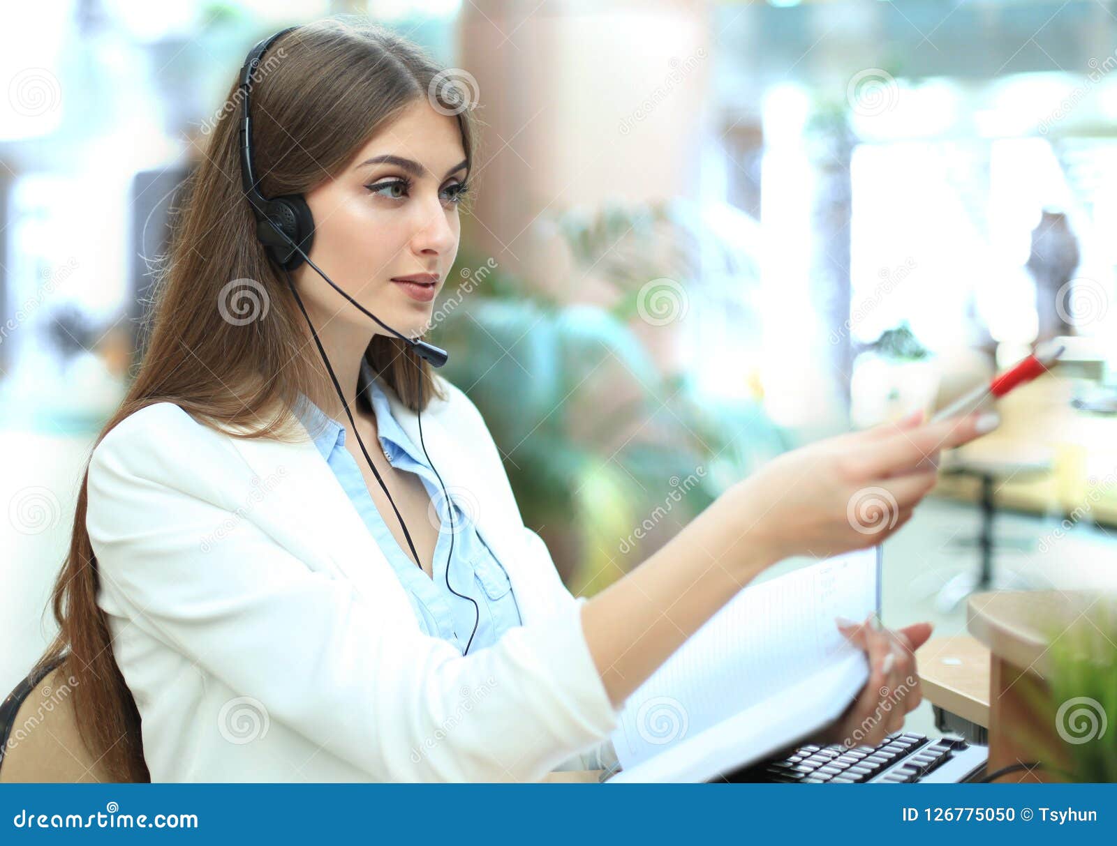 Smiling Call Center Agent Pointing at Something on Computer Screen in ...