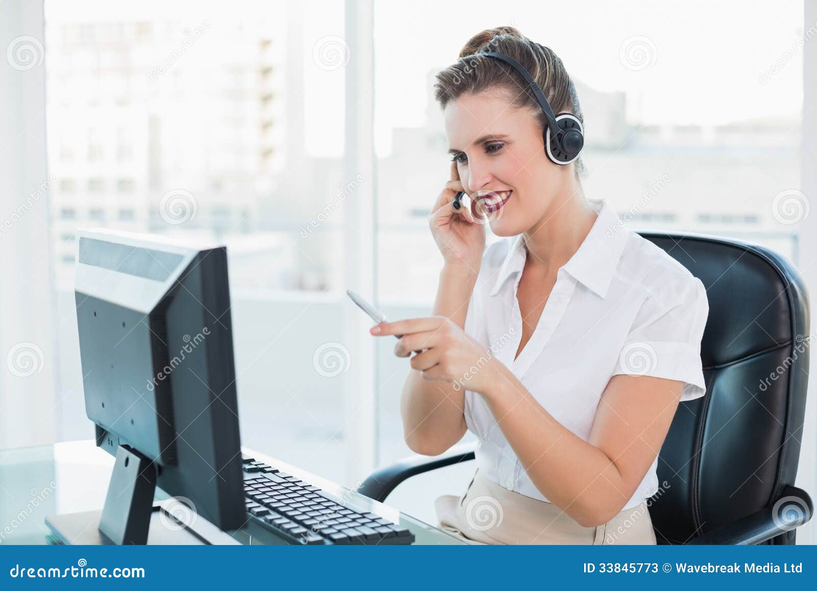 Smiling Call Centre Agent Pointing at Something on Computer Screen ...