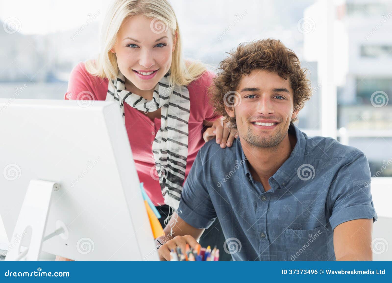 Smiling Casual Couple Using Computer in Bright Office Stock Photo ...