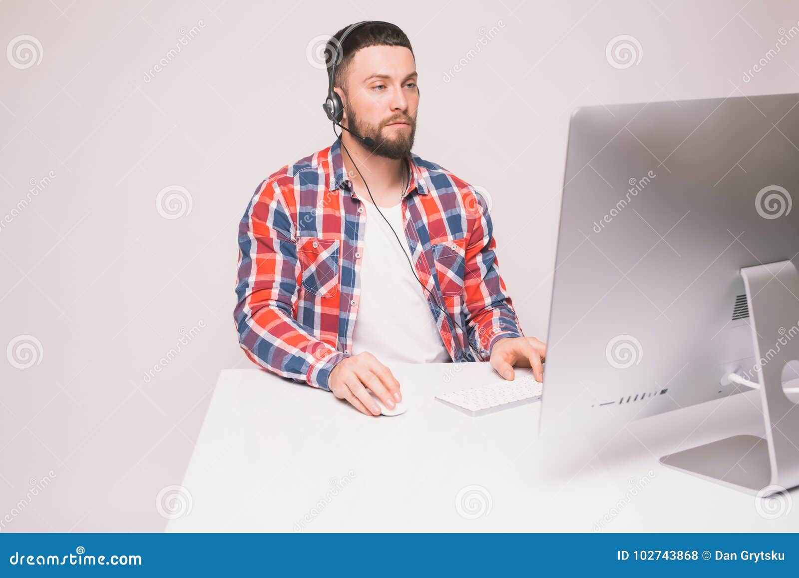 Casual Young Man with Headset Using Computer in a Bright Office Stock ...