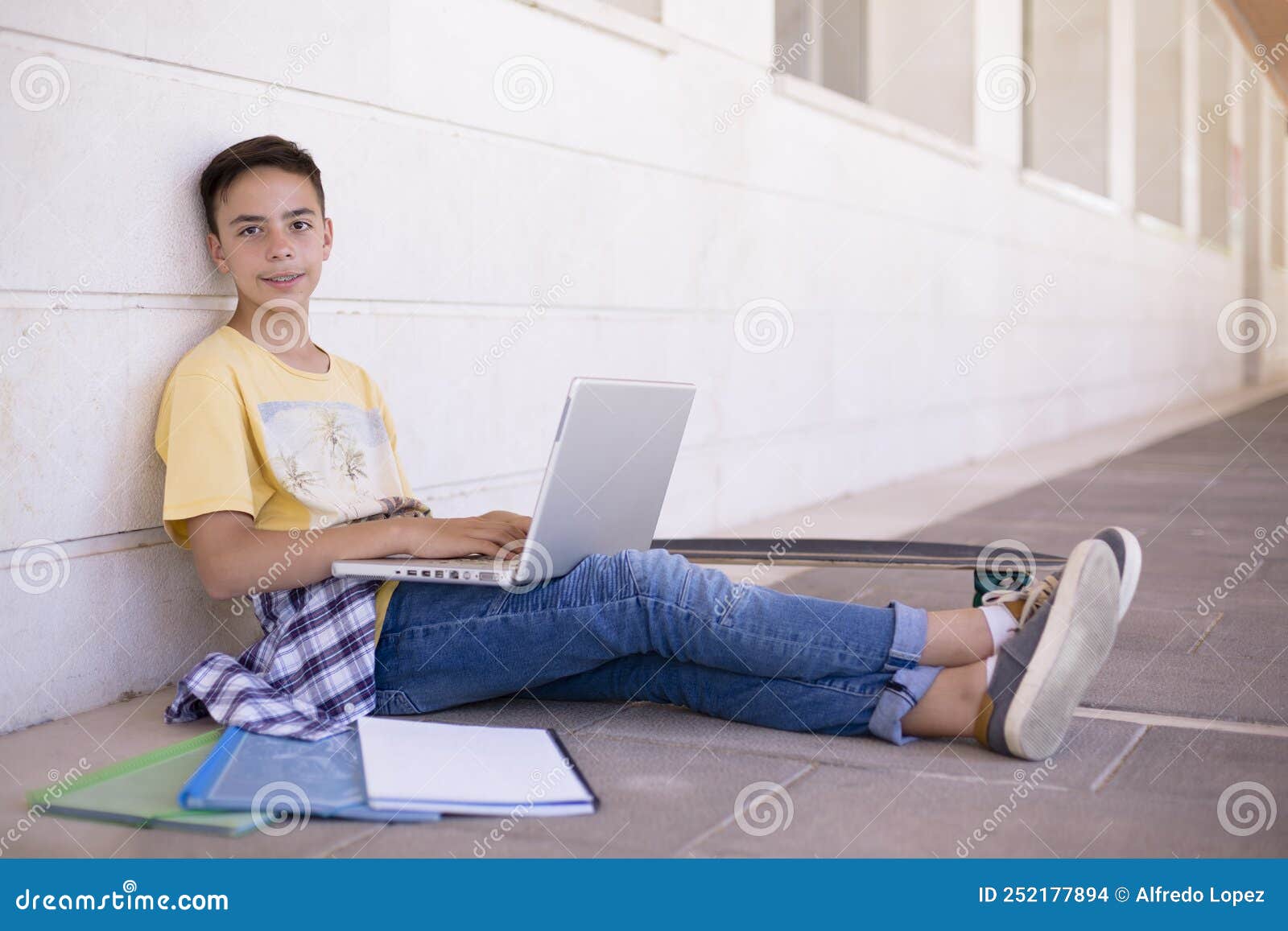 Smiling Caucasian Teenage Boy Sitting on the Floor Using Laptop ...