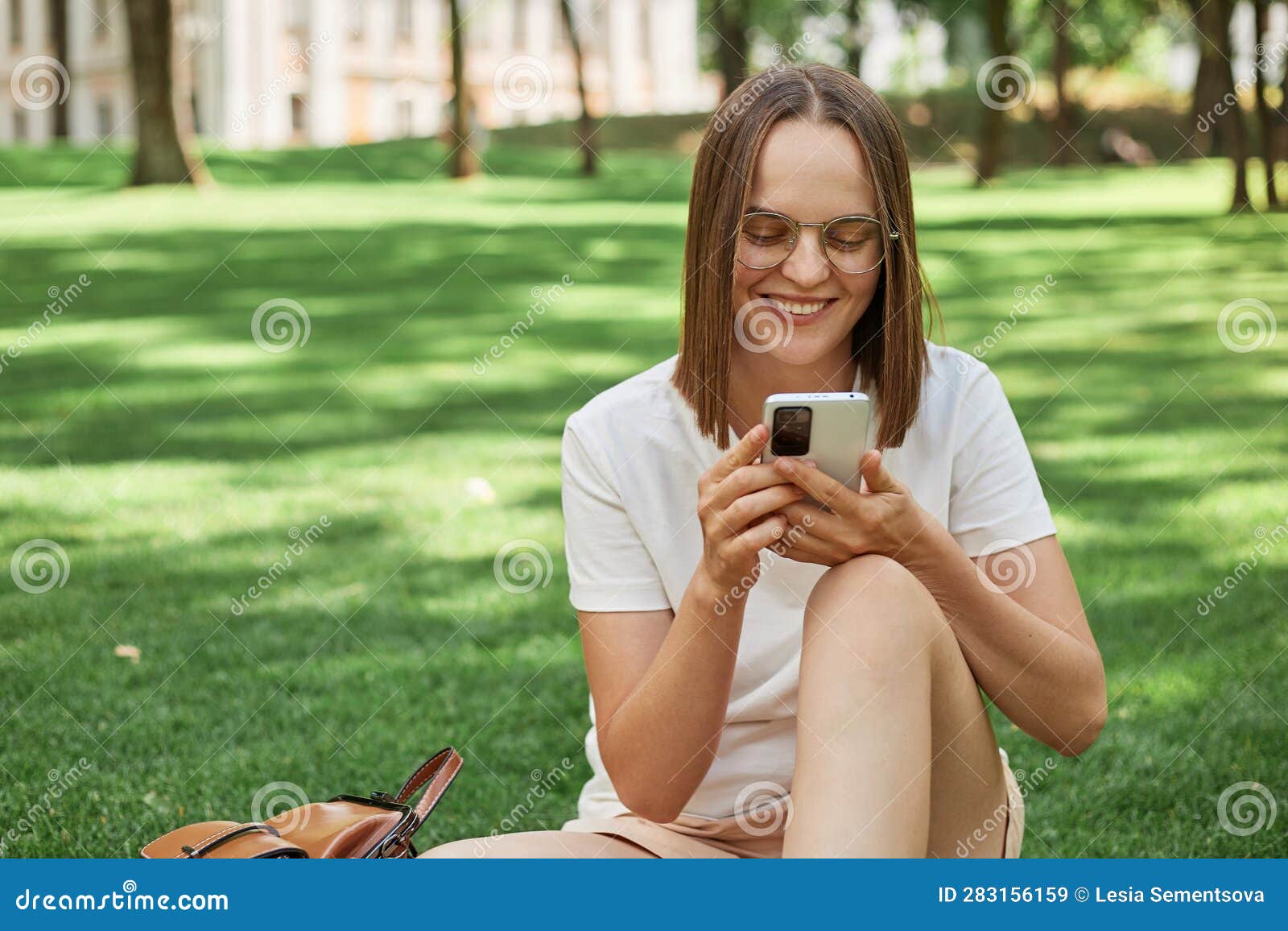 Smiling Cheerful Positive Woman Wearing Casual White T Shirt Sitting In