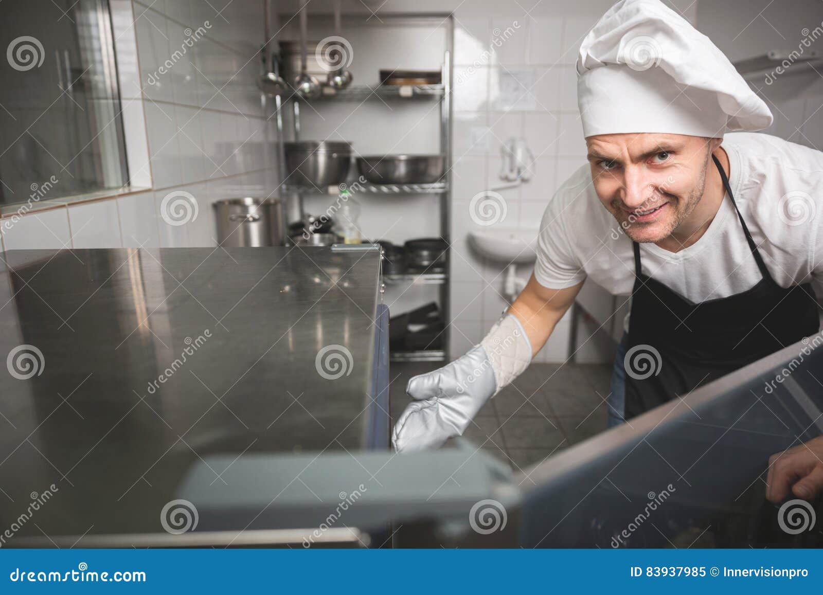 Smiling chef opening oven stock image. Image of indoors - 83937985