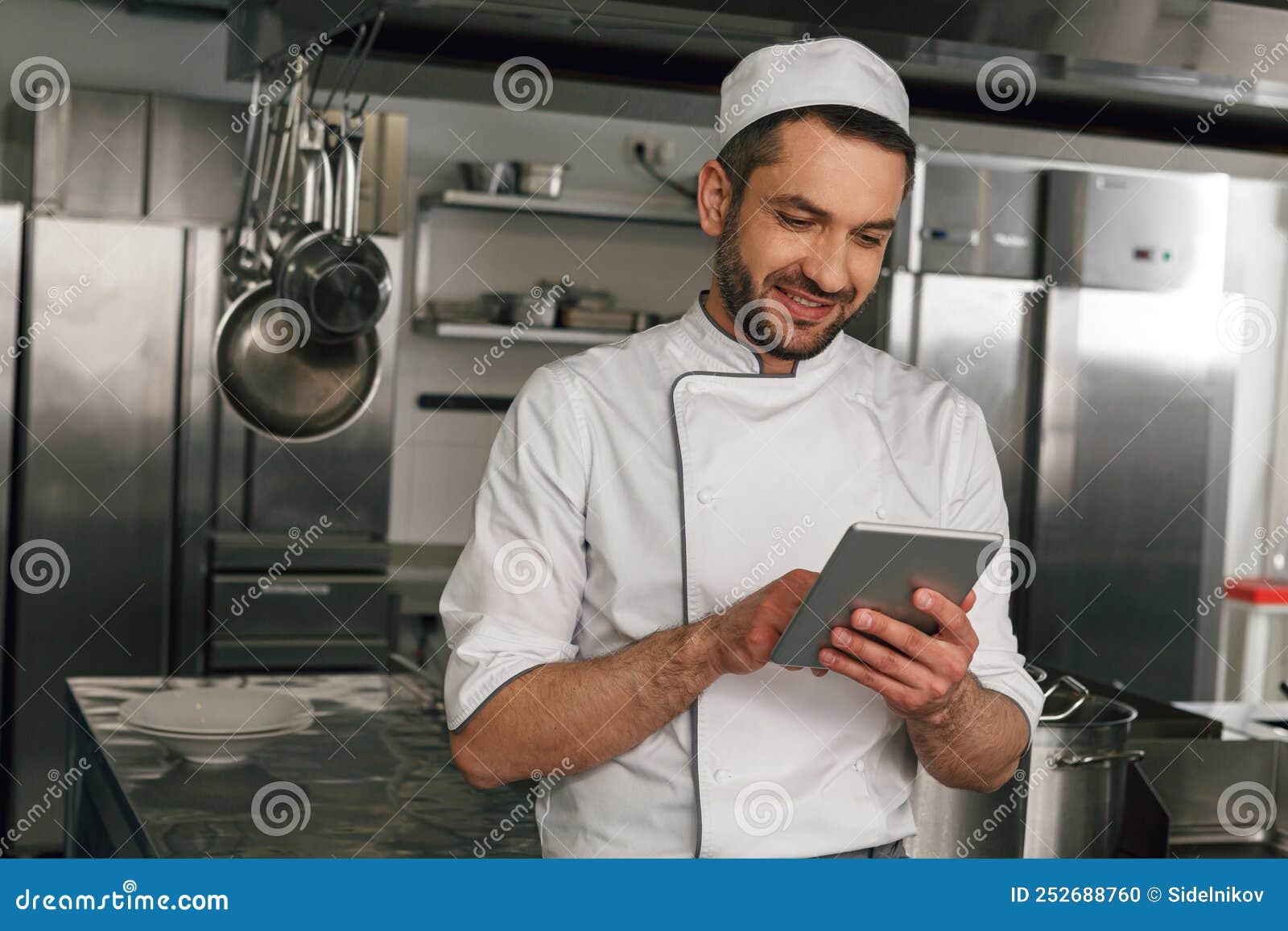 Smiling Chef in Uniform Making Order in Digital Tablet for the Supplier ...