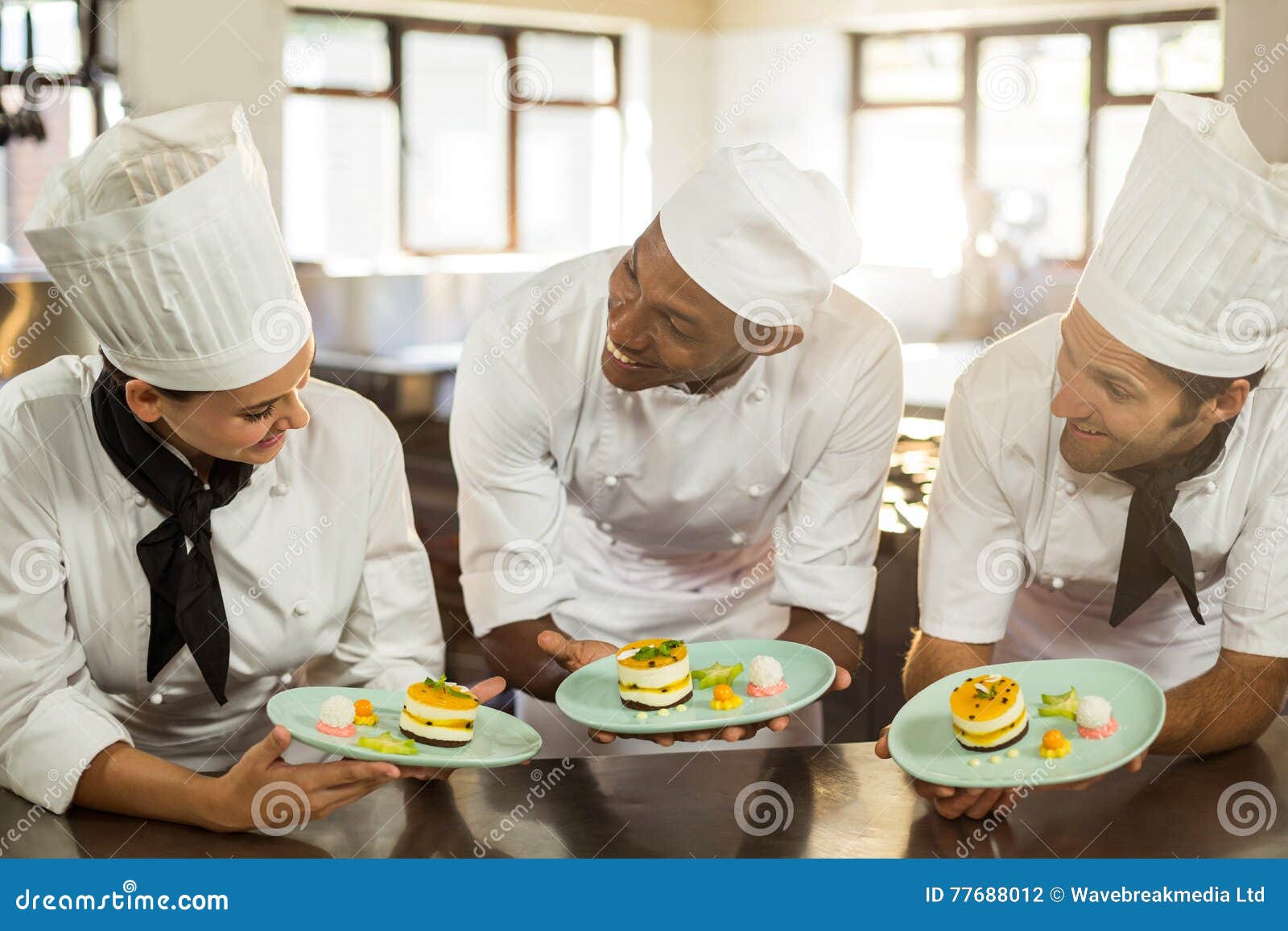 Smiling Chefs Team Holding Dessert Plates Stock Photo - Image of black ...