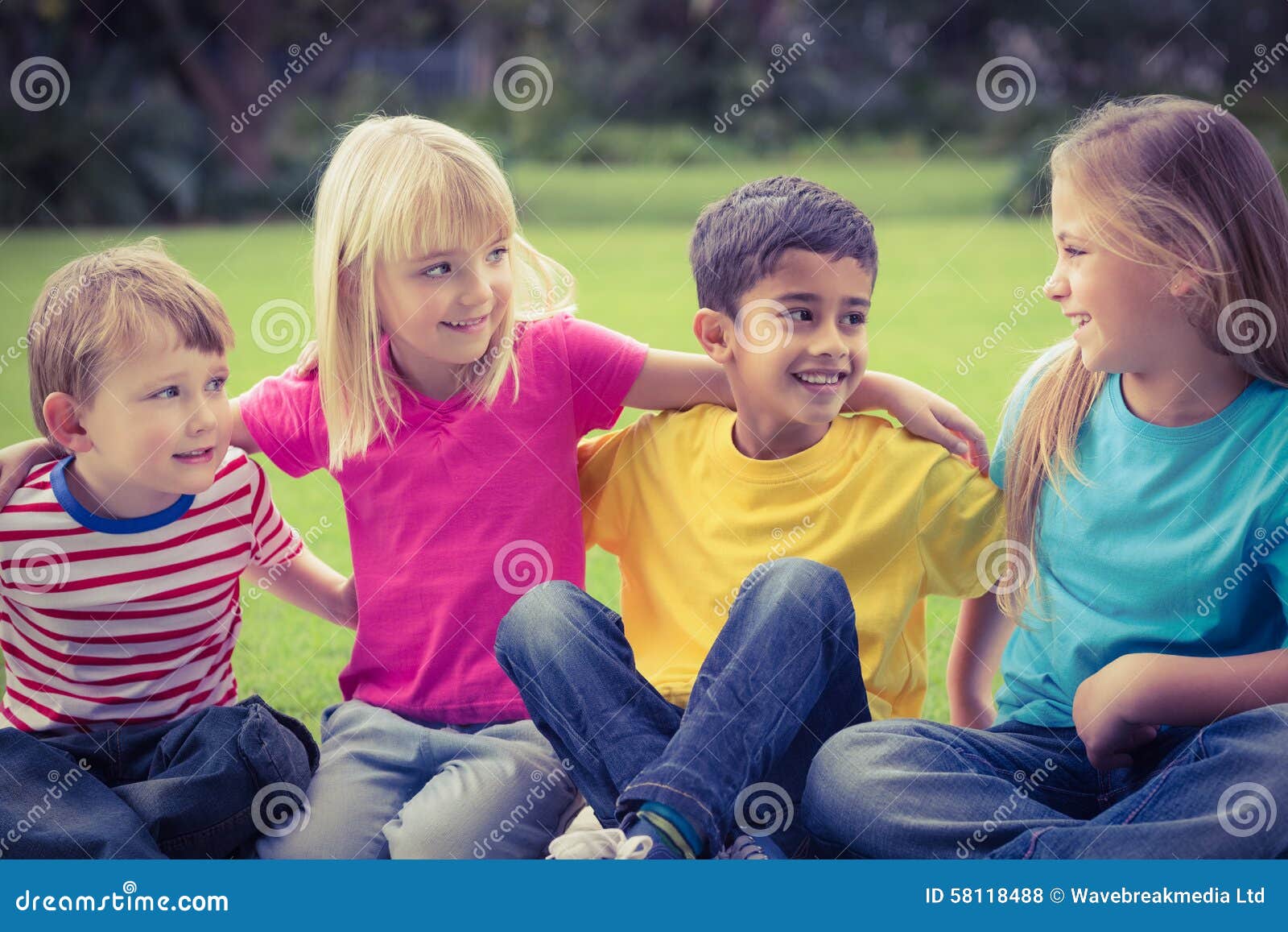 Smiling Classmates Talking and Sitting in Grass Stock Photo - Image of ...