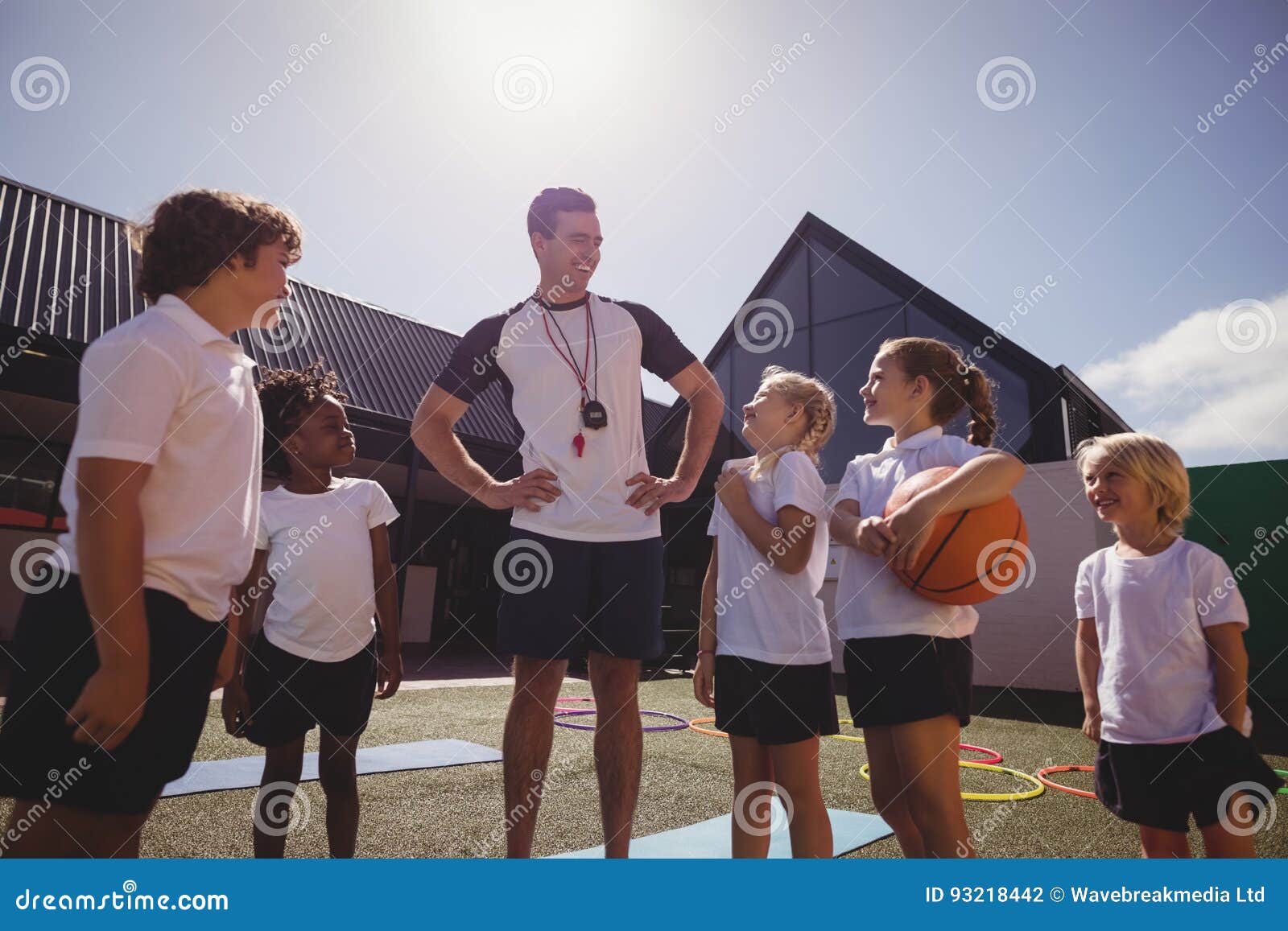 Smiling Coach and Schoolkids Interacting with Each Other Stock Photo ...