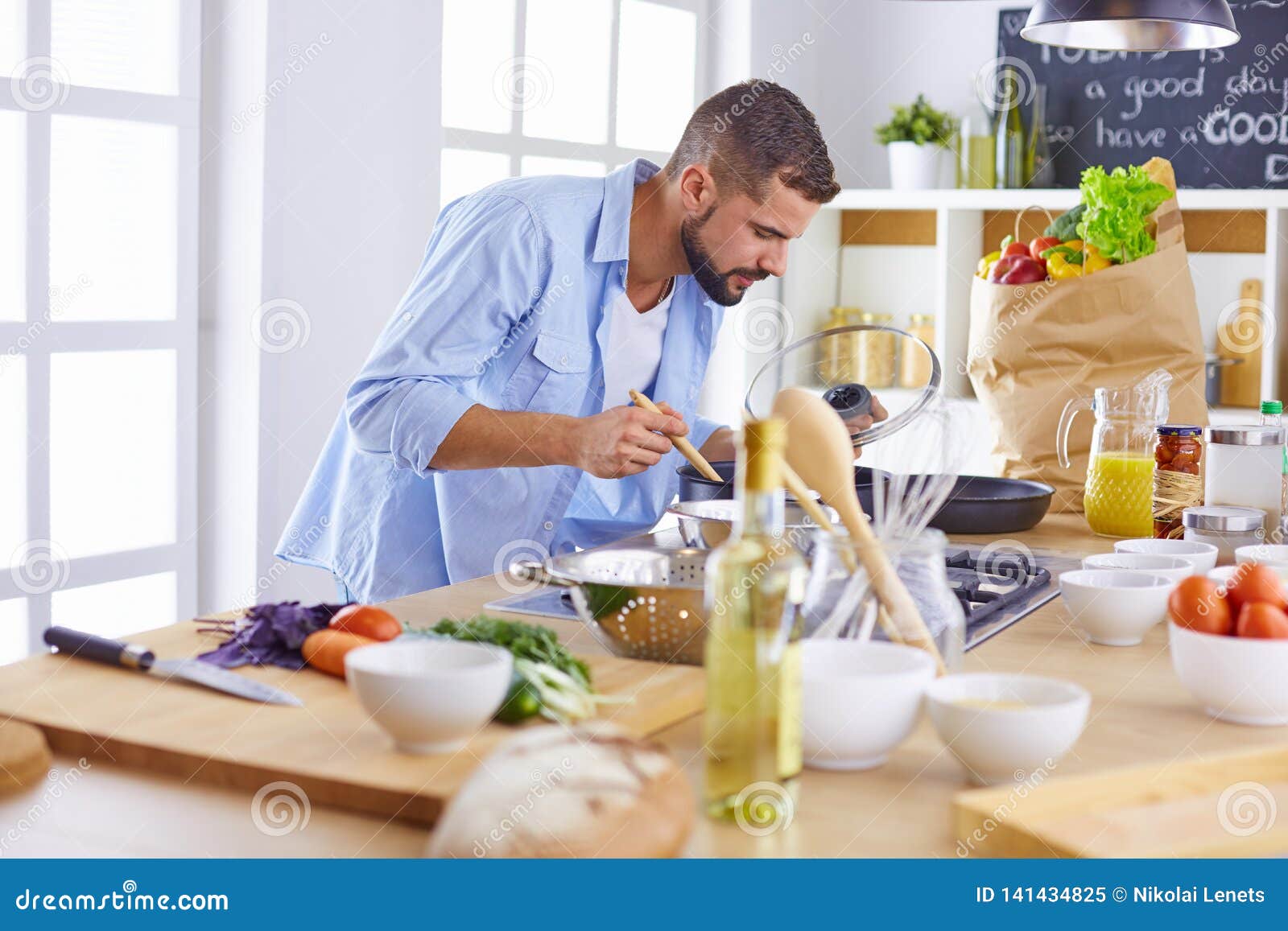 Smiling and Confident Chef Standing in a Large Kitchen Tasting a Cooked ...
