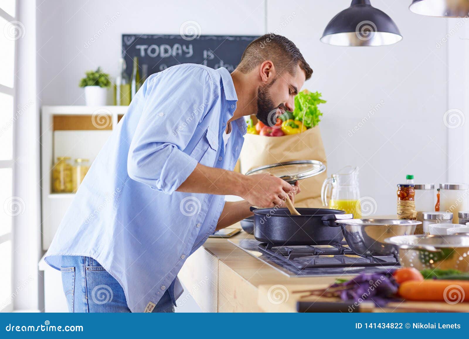 Smiling and Confident Chef Standing in a Large Kitchen Tasting a Cooked ...