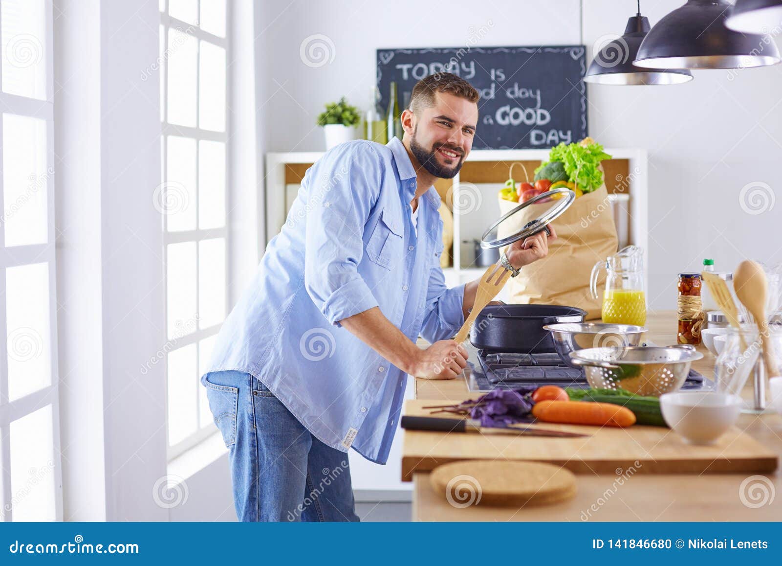 Smiling and Confident Chef Standing in a Large Kitchen Tasting a Cooked ...
