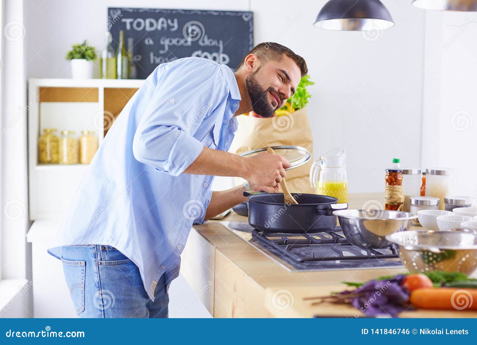 Smiling and Confident Chef Standing in a Large Kitchen Tasting a Cooked ...