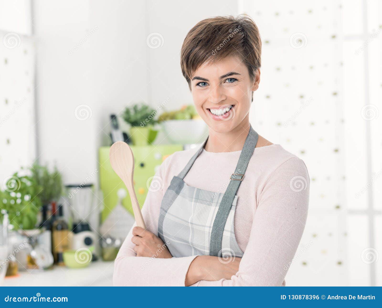 Smiling Confident Young Woman with Apron Posing in the Kitchen Stock ... Smiling Confident Young Woman with Apron Posing in the Kitchen Stock ...