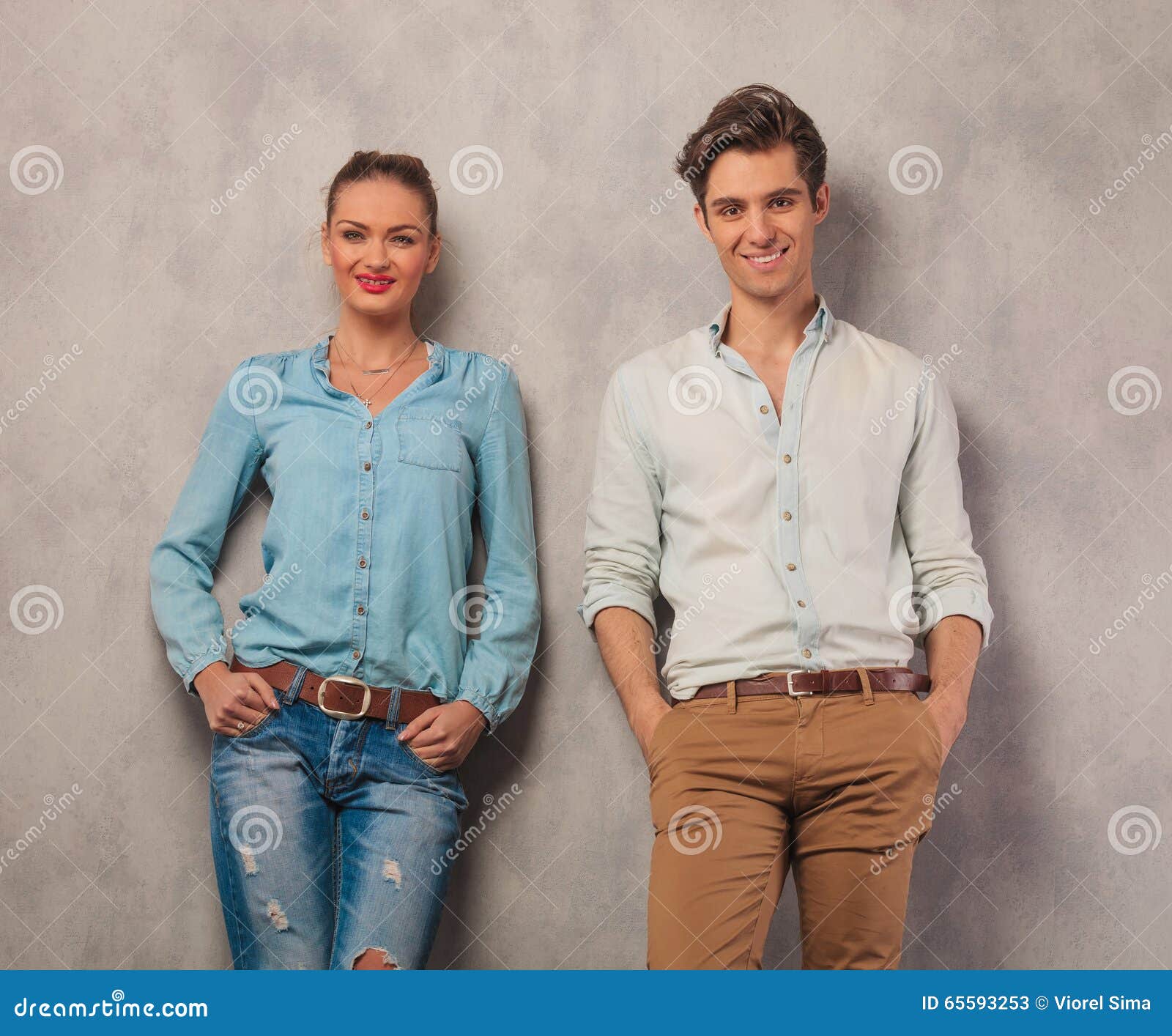 Smiling Couple Leaning Against the Wall with Hands in Pockets Stock ...