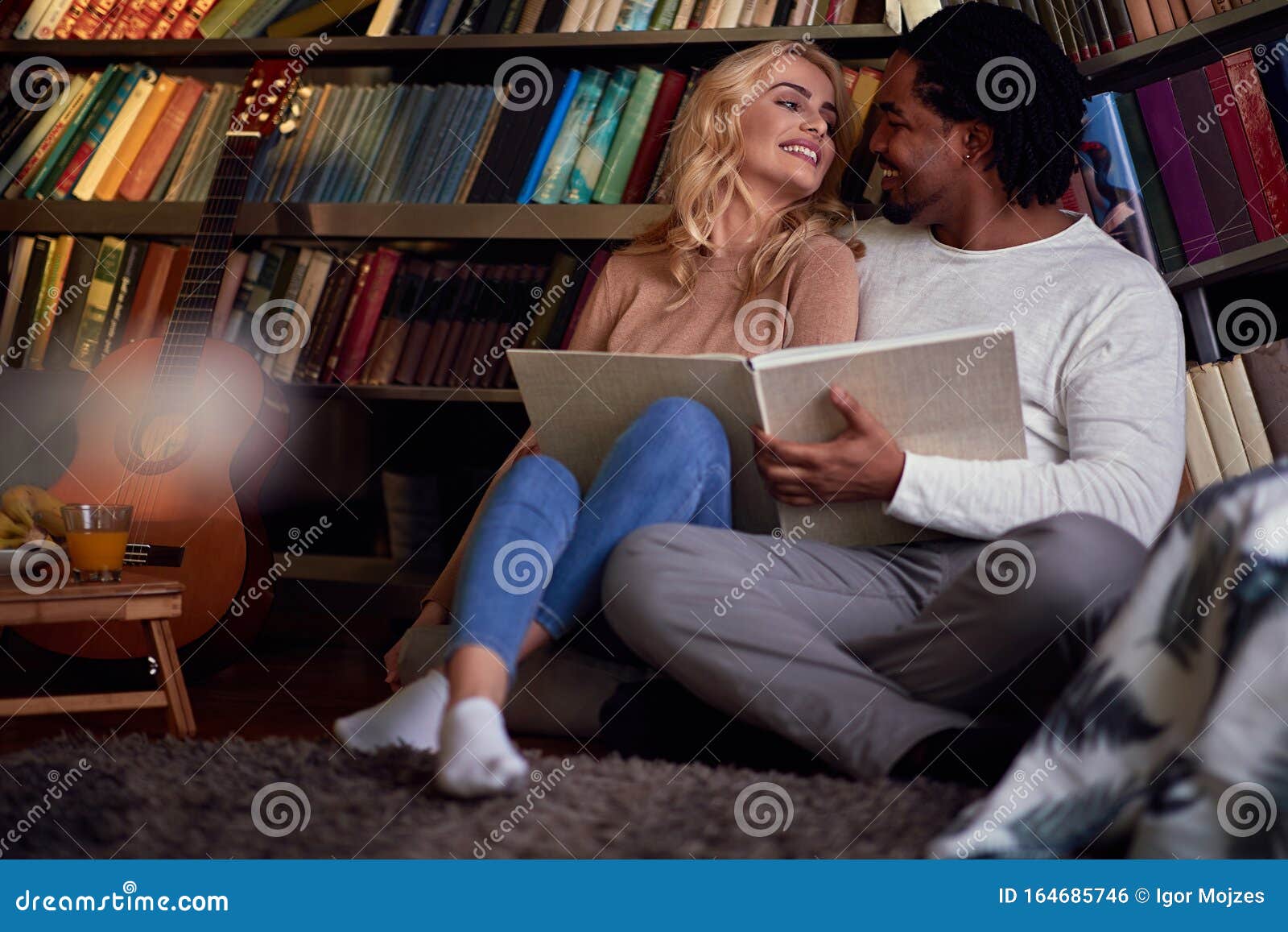 Smiling Couple Reading A Book Together Enjoying Reading At Home Stock
